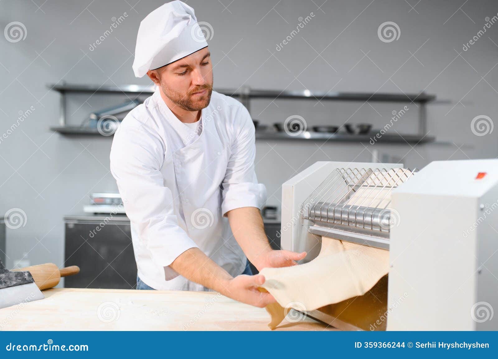 Concentrated at Work. Handsome Chef Rolling a Dough through Pasta ...