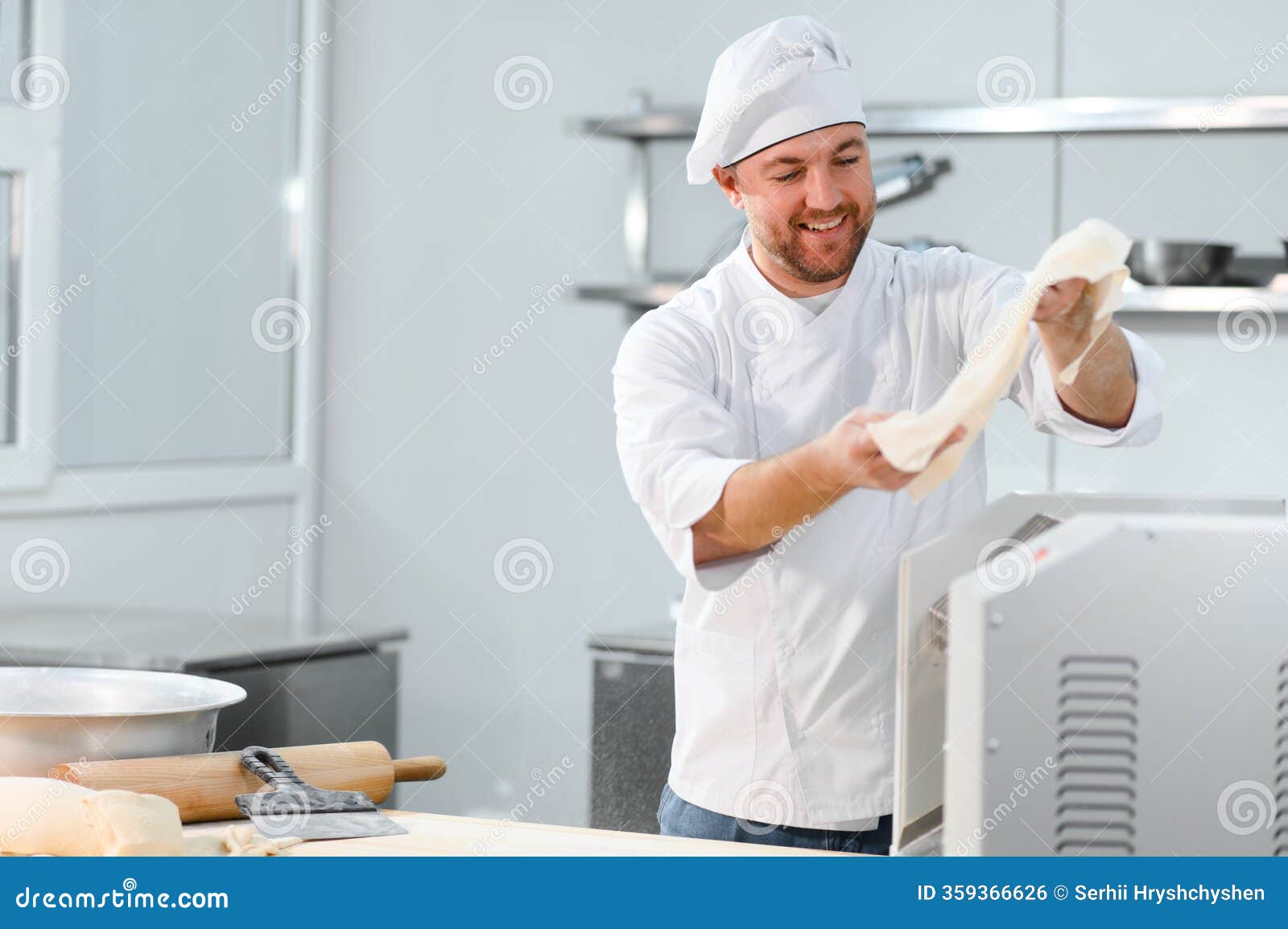 Concentrated at Work. Handsome Chef Rolling a Dough through Pasta ...
