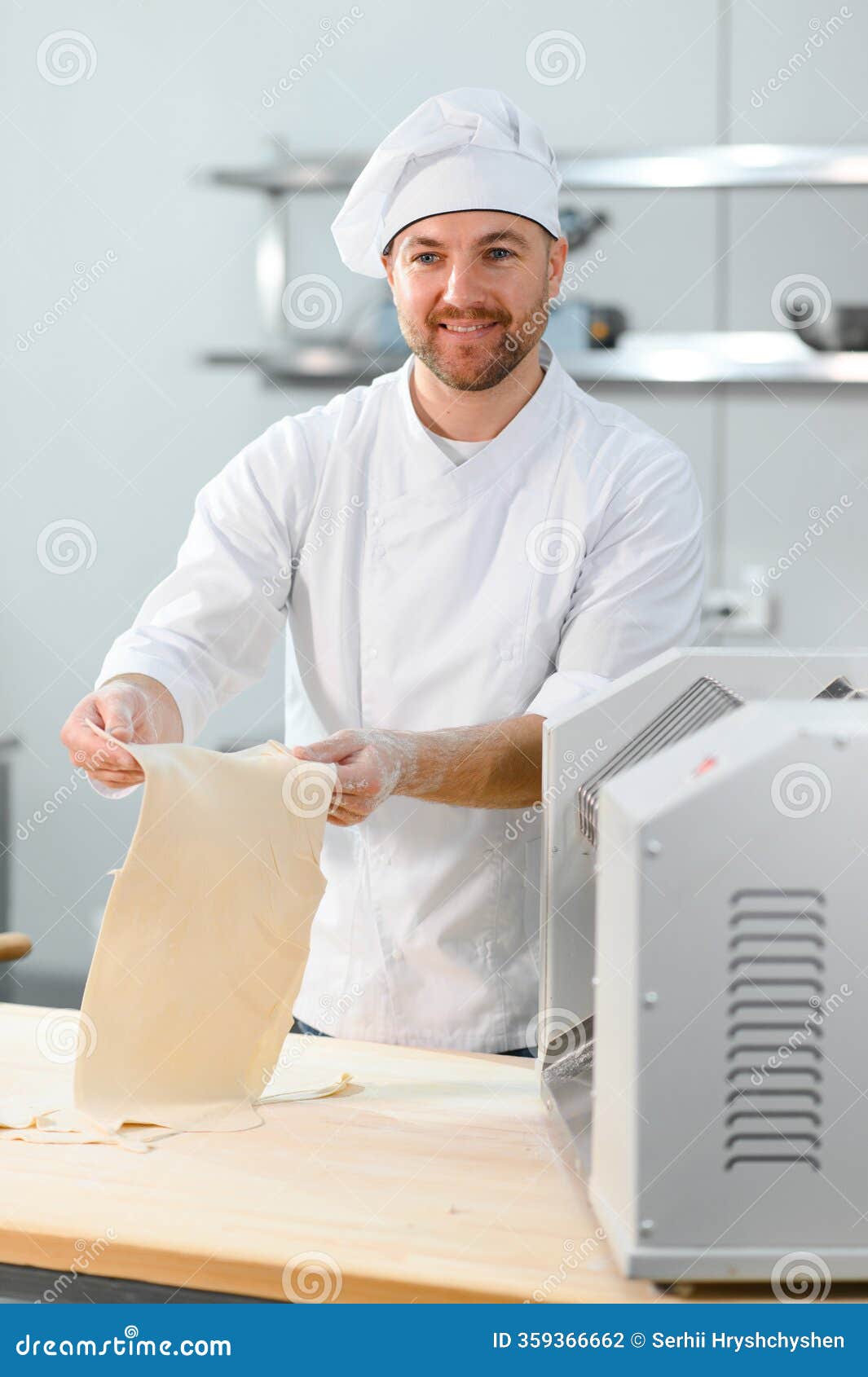 Concentrated at Work. Handsome Chef Rolling a Dough through Pasta ...