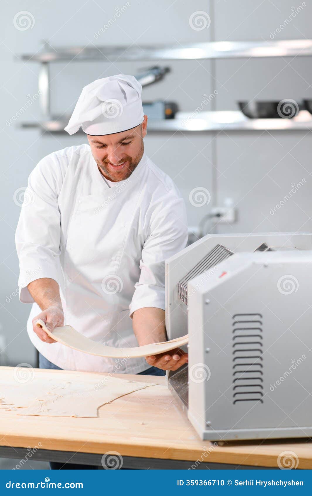 Concentrated at Work. Handsome Chef Rolling a Dough through Pasta ...