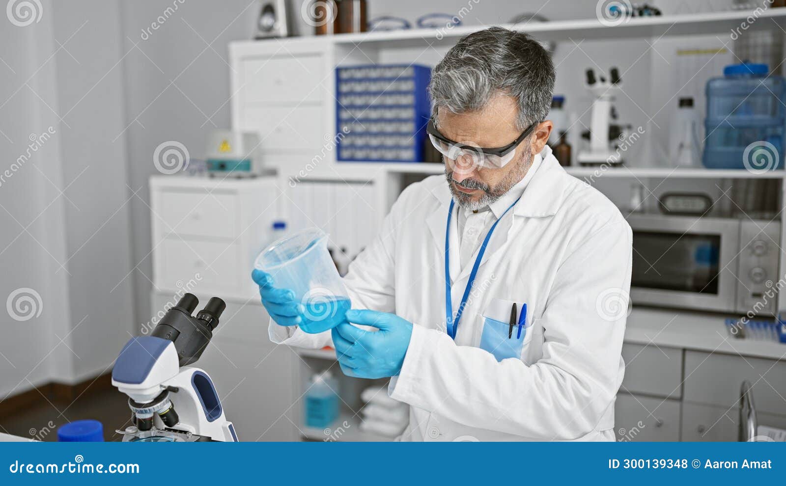 Concentrated Young Hispanic Man, Grey-haired and Handsome, Meticulously Measuring Liquid for a ...