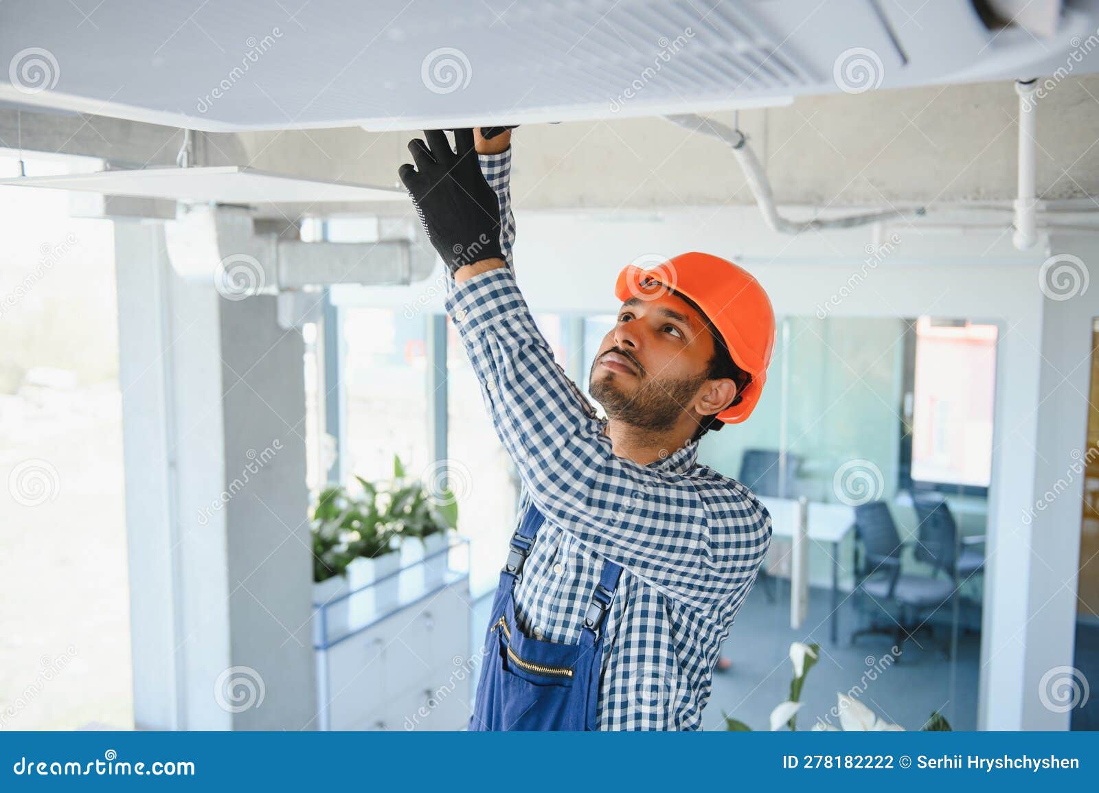 Concentrated Young Indian Engineer Setting Up Air Conditioner. Stock ...
