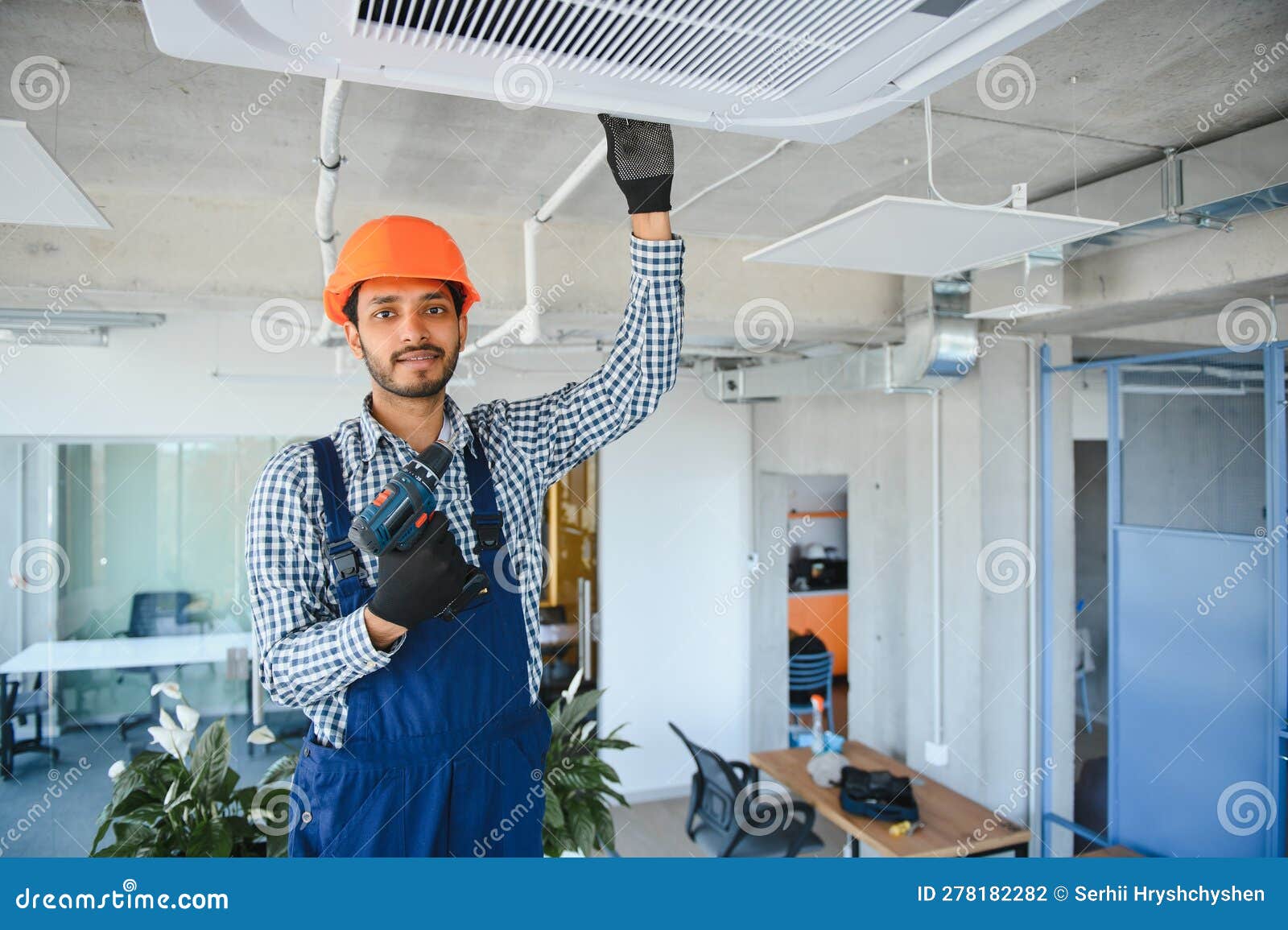 Concentrated Young Indian Engineer Setting Up Air Conditioner. Stock ...