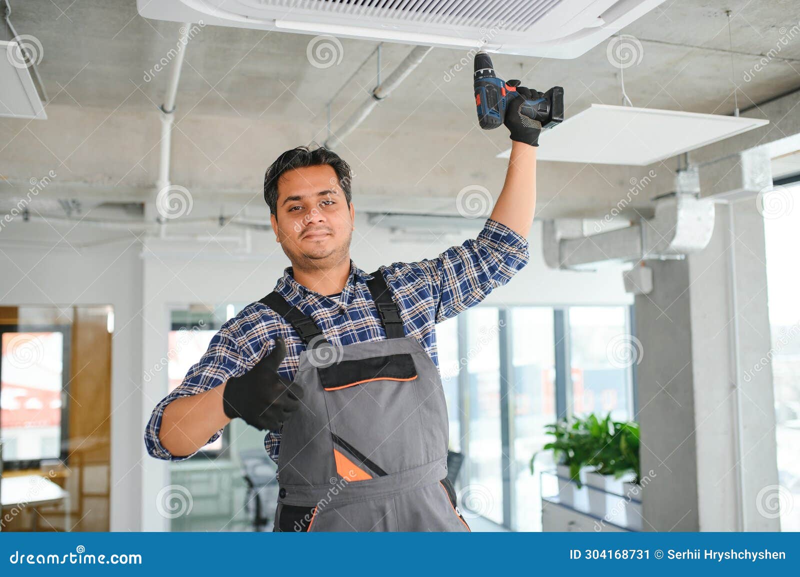 Concentrated Young Indian Engineer Setting Up Air Conditioner. Stock ...