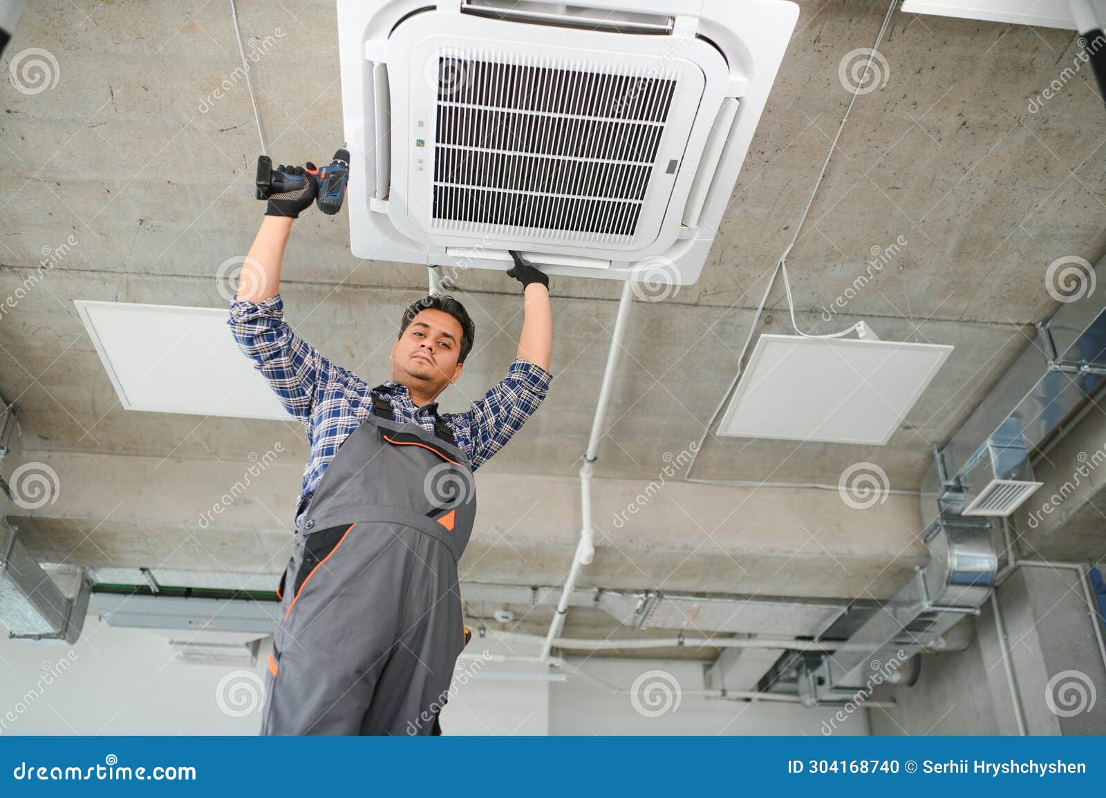 Concentrated Young Indian Engineer Setting Up Air Conditioner. Stock ...