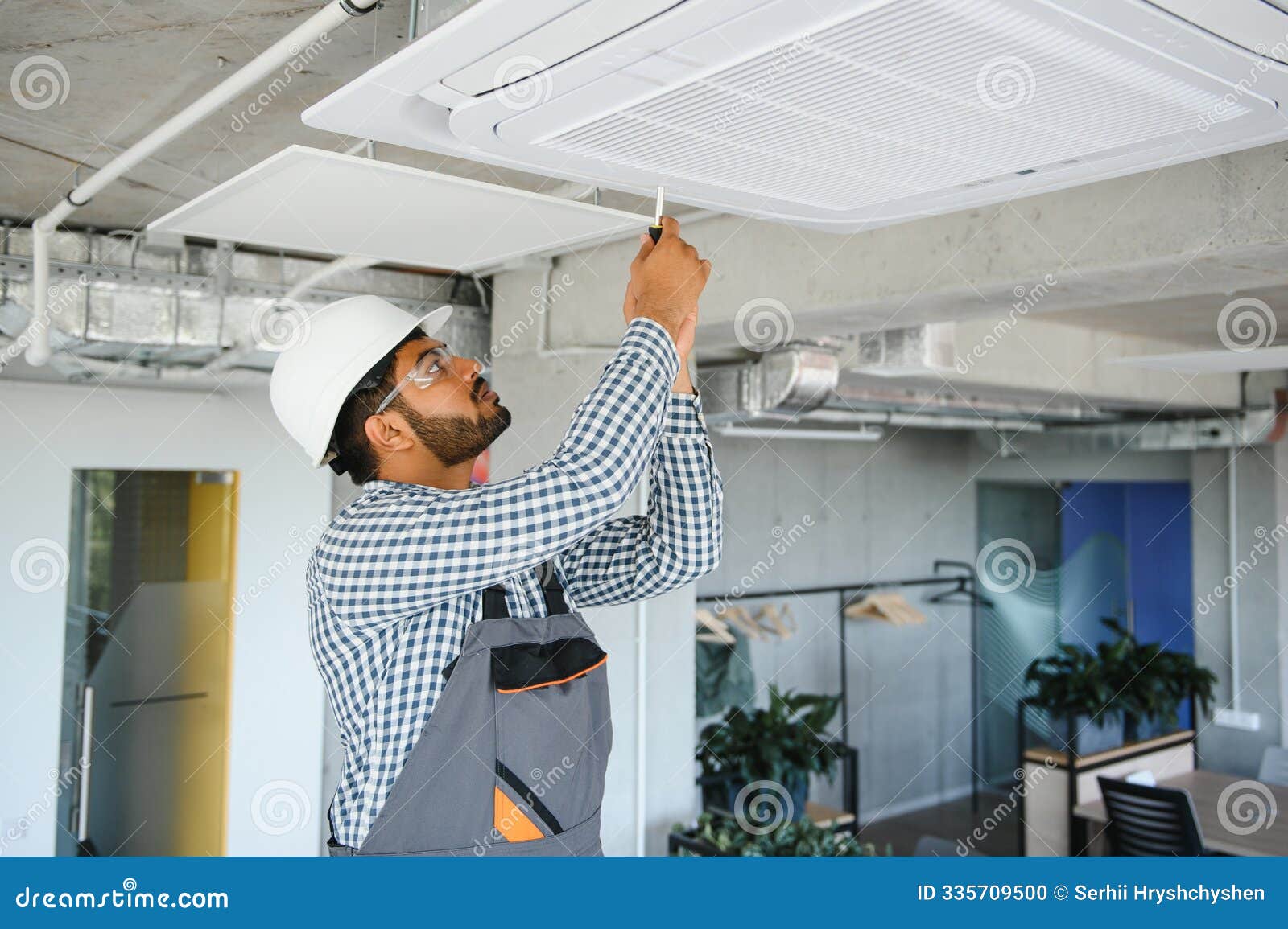 Concentrated Young Indian Engineer Setting Up Air Conditioner Stock ...