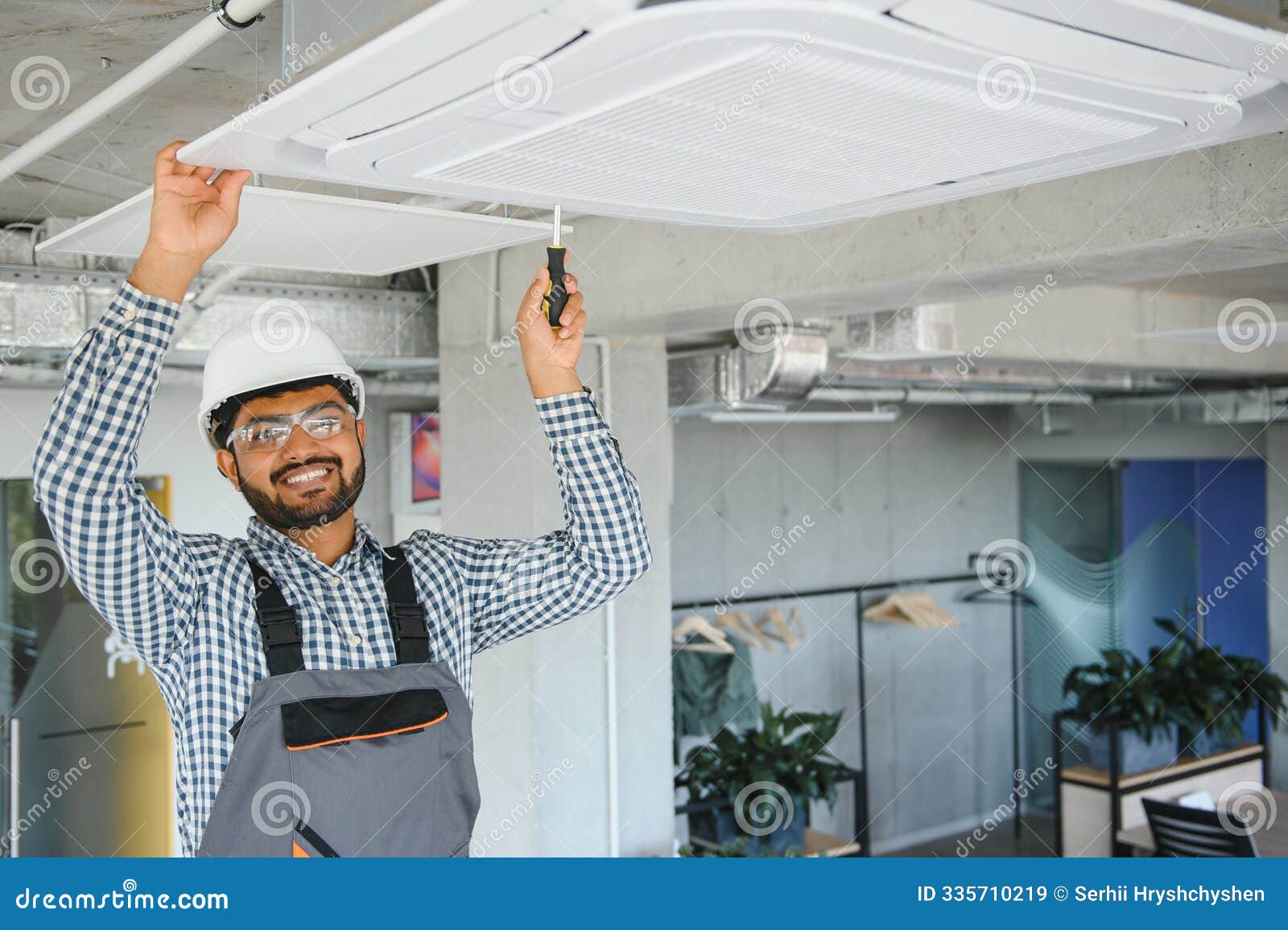 Concentrated Young Indian Engineer Setting Up Air Conditioner Stock ...