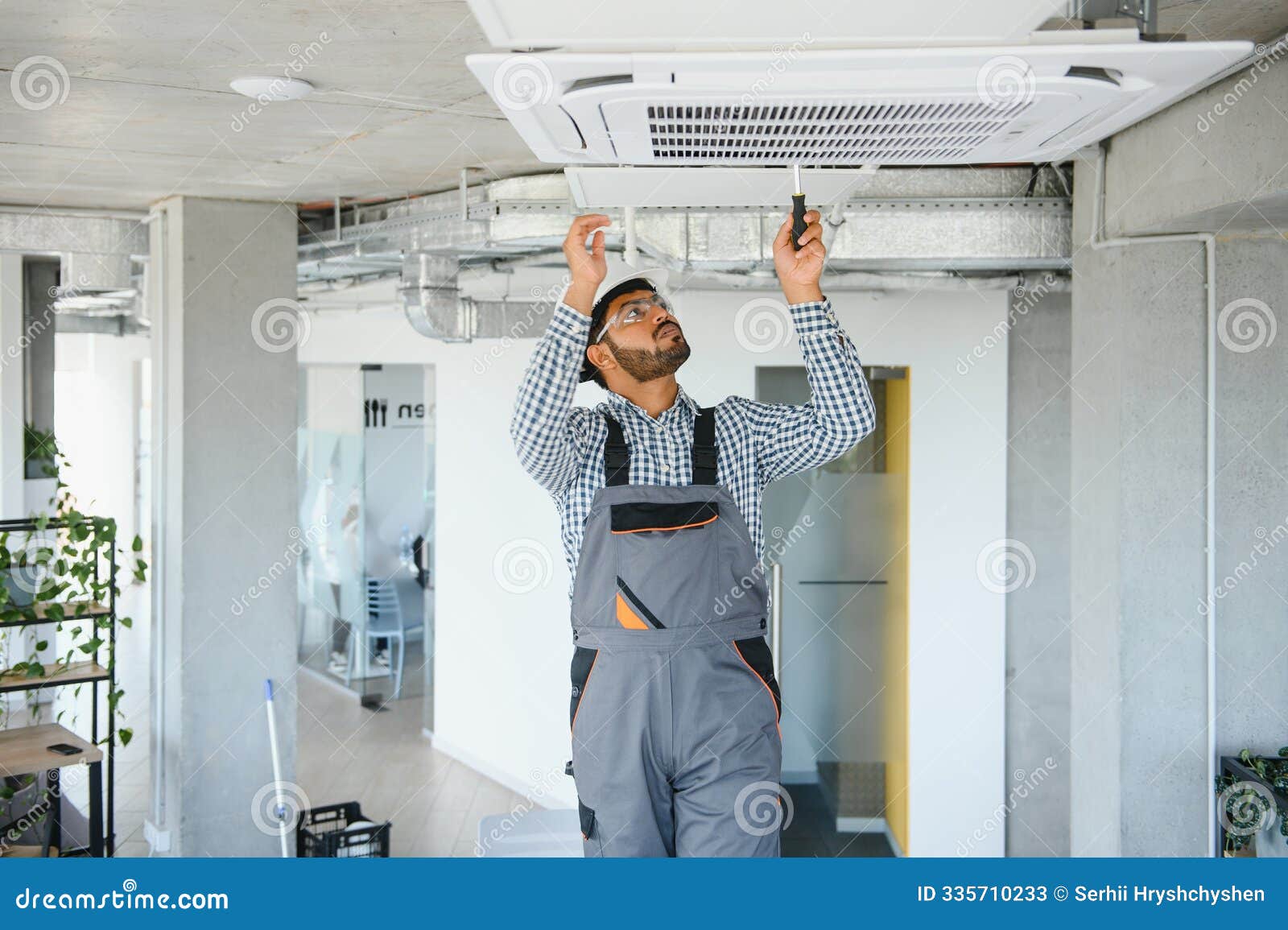 Concentrated Young Indian Engineer Setting Up Air Conditioner Stock ...