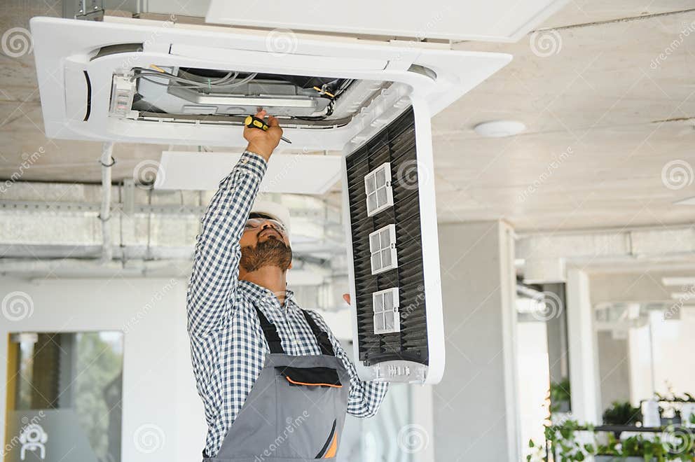 Concentrated Young Indian Engineer Setting Up Air Conditioner Stock ...
