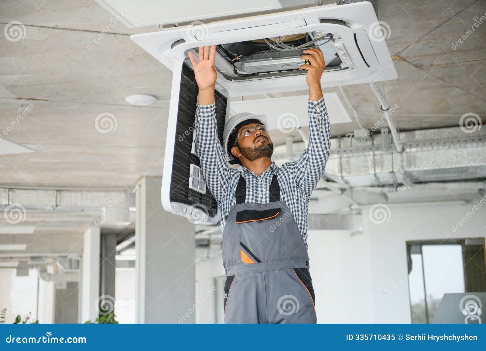 Concentrated Young Indian Engineer Setting Up Air Conditioner Stock ...