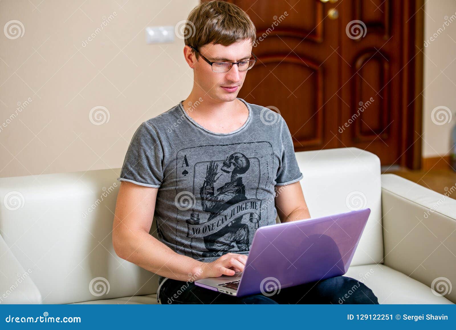 Concentrated Young Man with Glasses Working on a Laptop in a Home ...