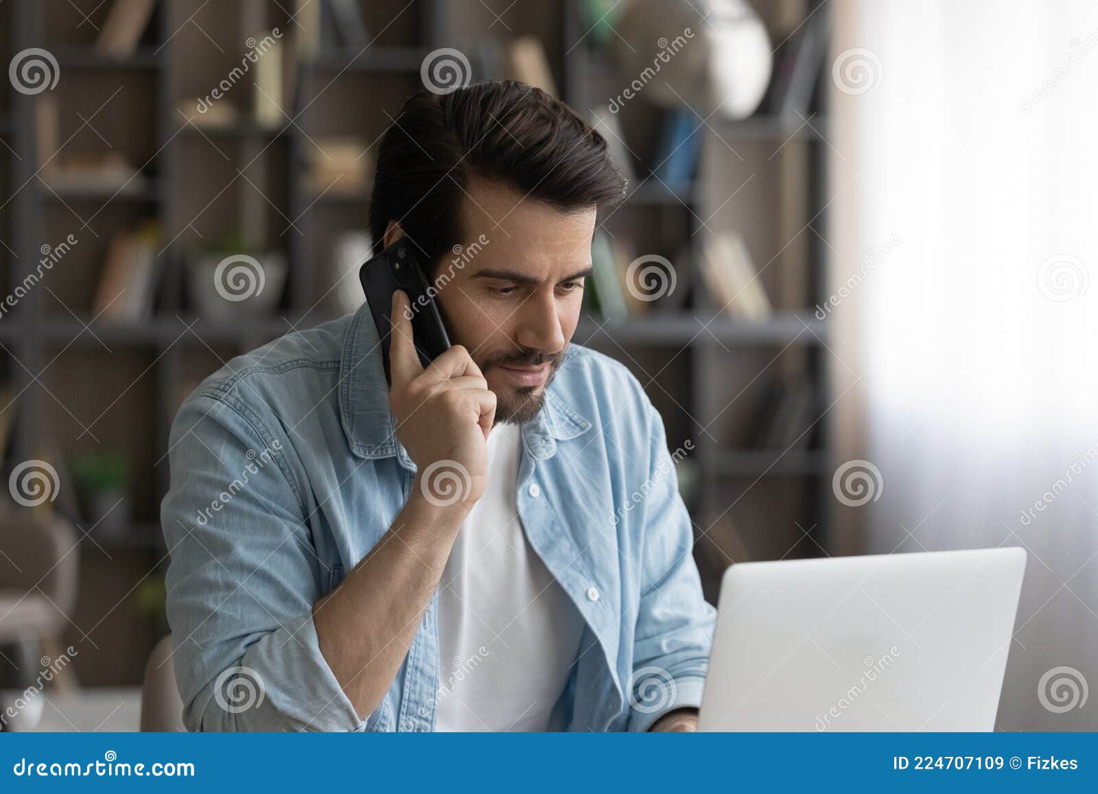 Concentrated Young Salesman In Uniform Checking Laser Level At Hardware ...