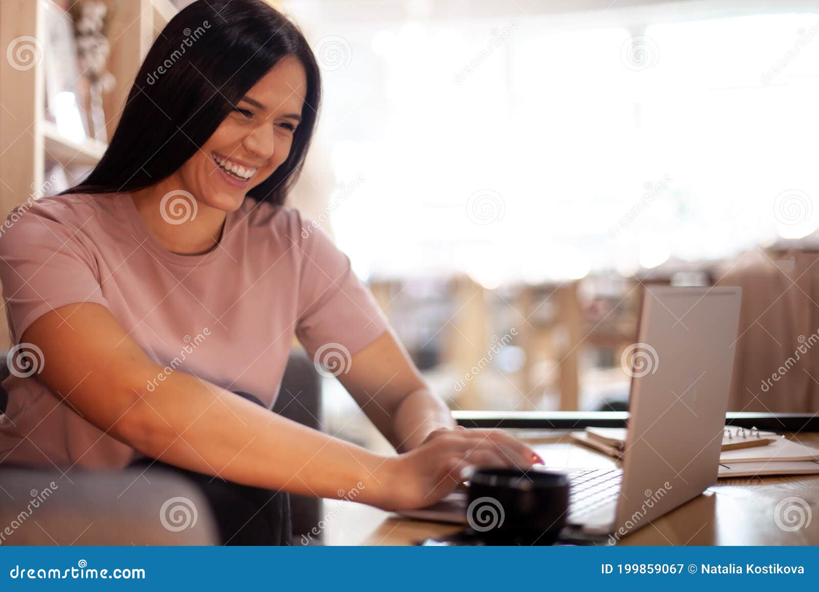 Concentrated Young Woman Typing on Computer while Having a Coffee Break ...