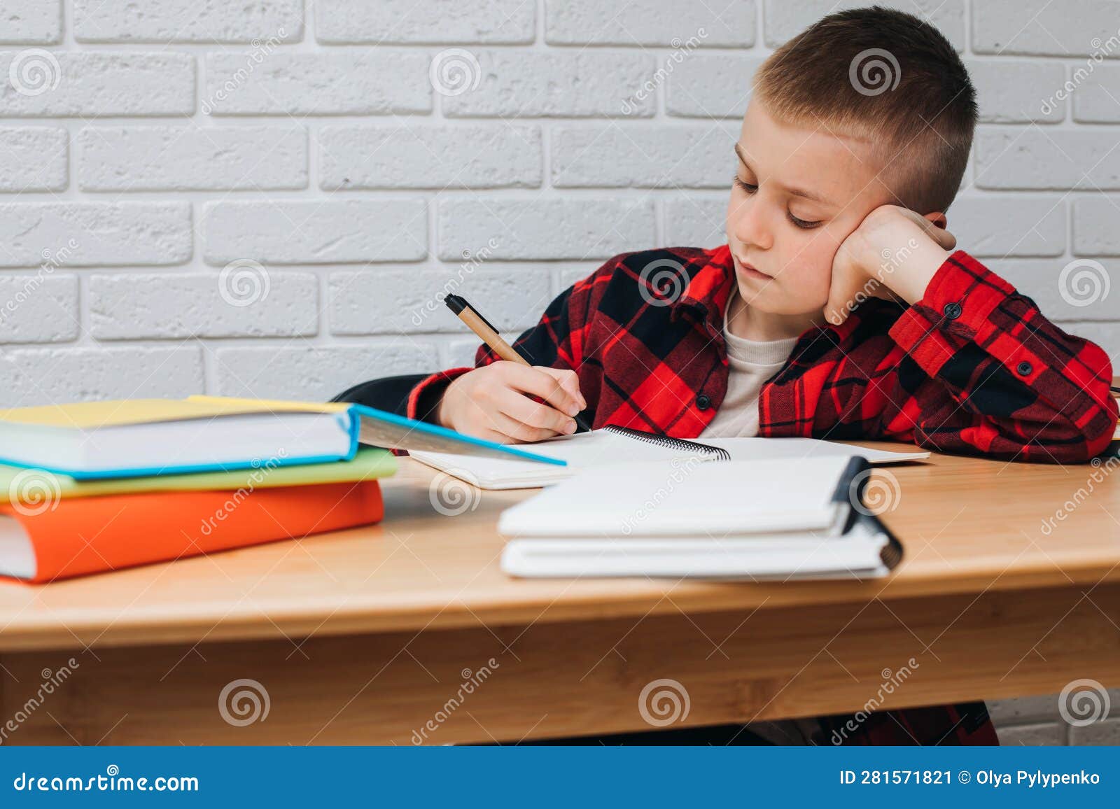 Concept Back To the School. a Boy in the Process of Studying Sits at a ...