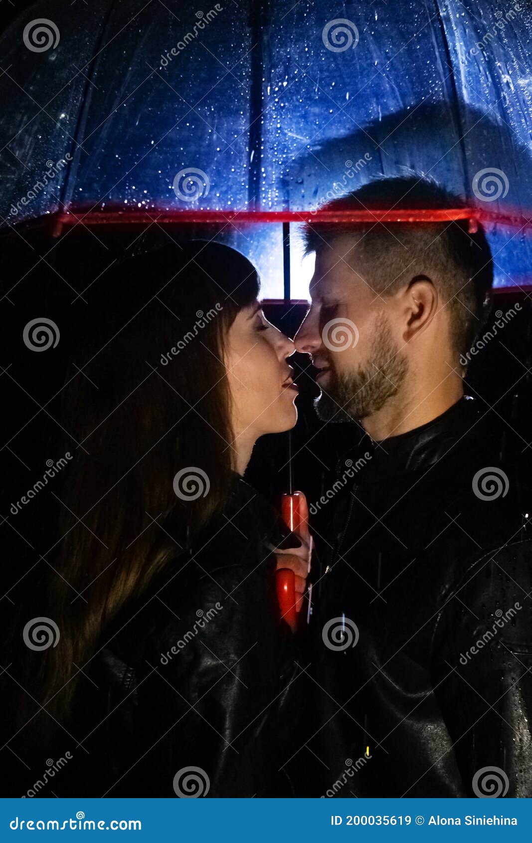 A Couple In Love Under An Umbrella Kissing And Rain Is Falling On Them