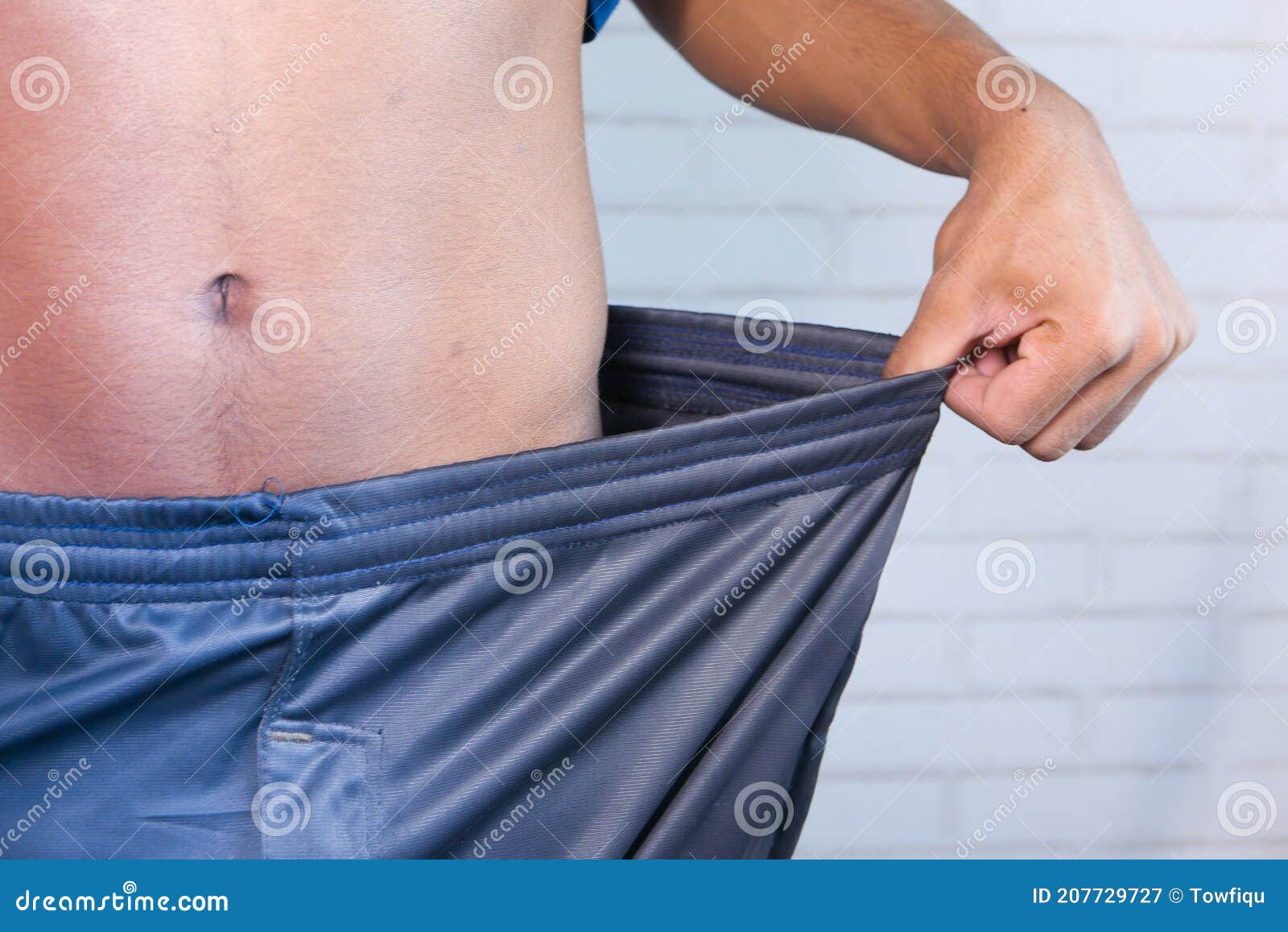 The Concept of Weight Loss, Young Man Pulling Pant Stock Image - Image ...