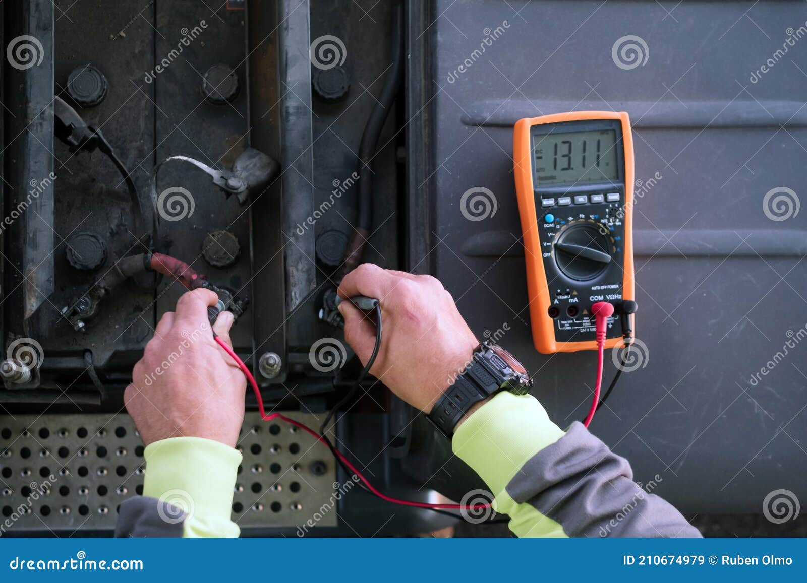 Concept: Work and Technology. Hands Testing a Battery with a Voltmeter ...