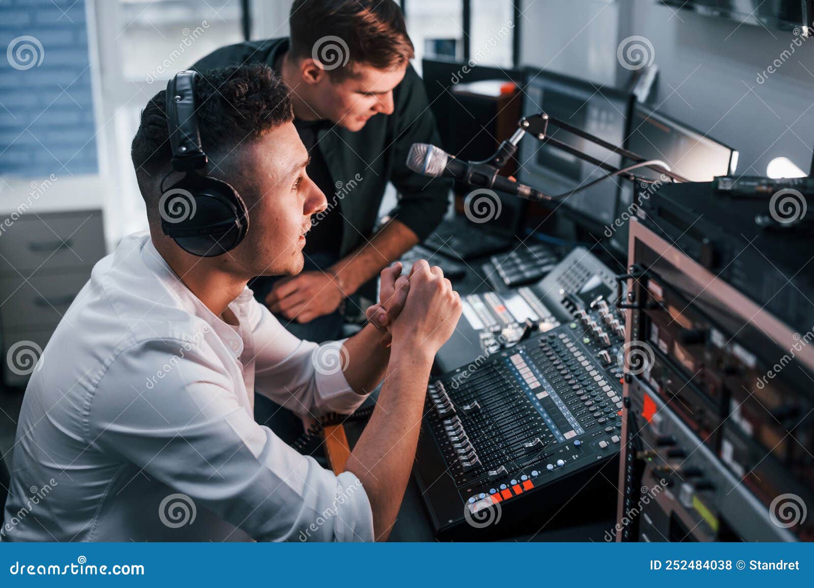 Conception of Teamwork. Two Guys is Indoors in the Radio Studio is Busy ...