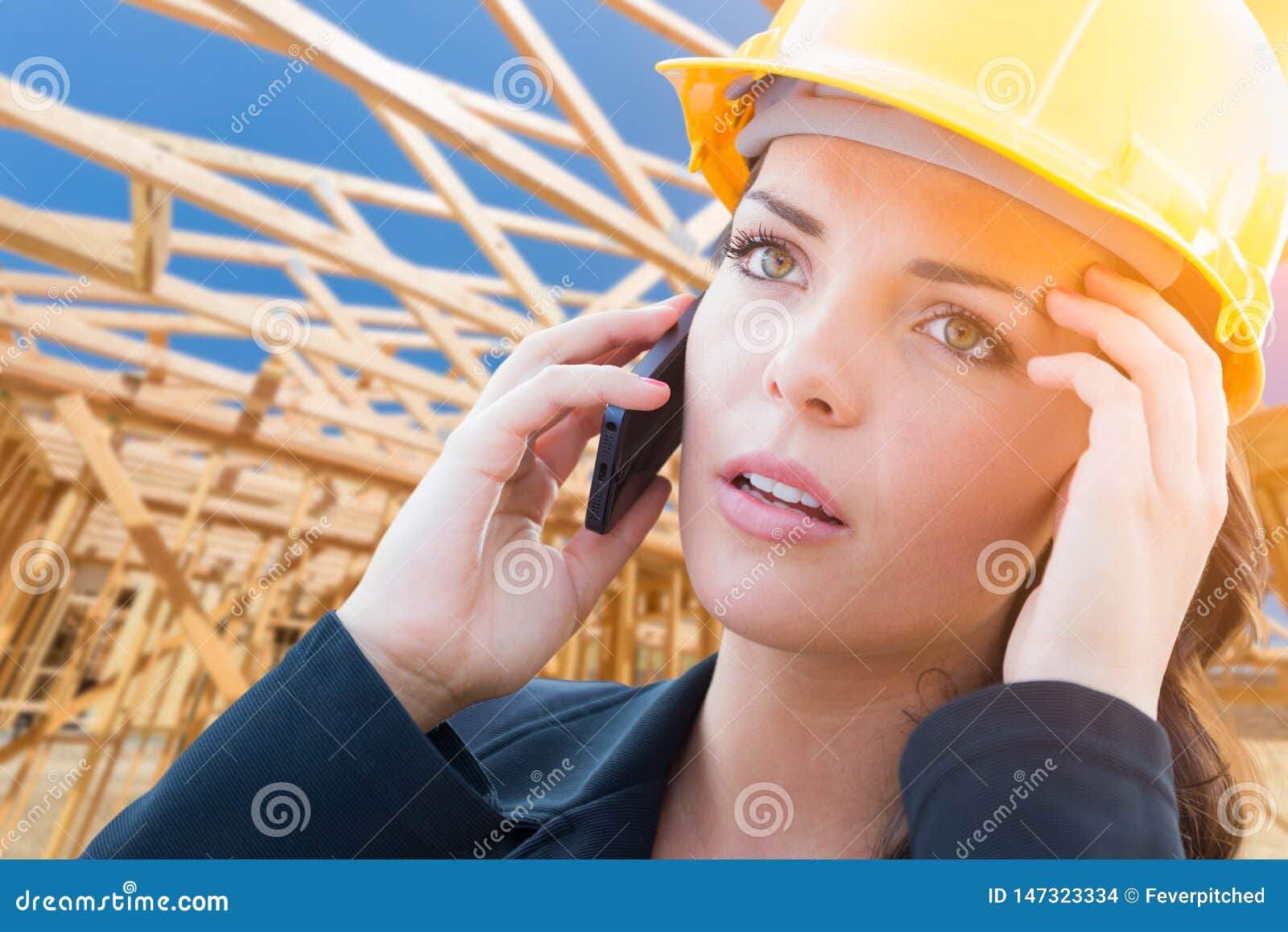 Concerned Female Contractor in Hard Hat Using Cell Phone at ...