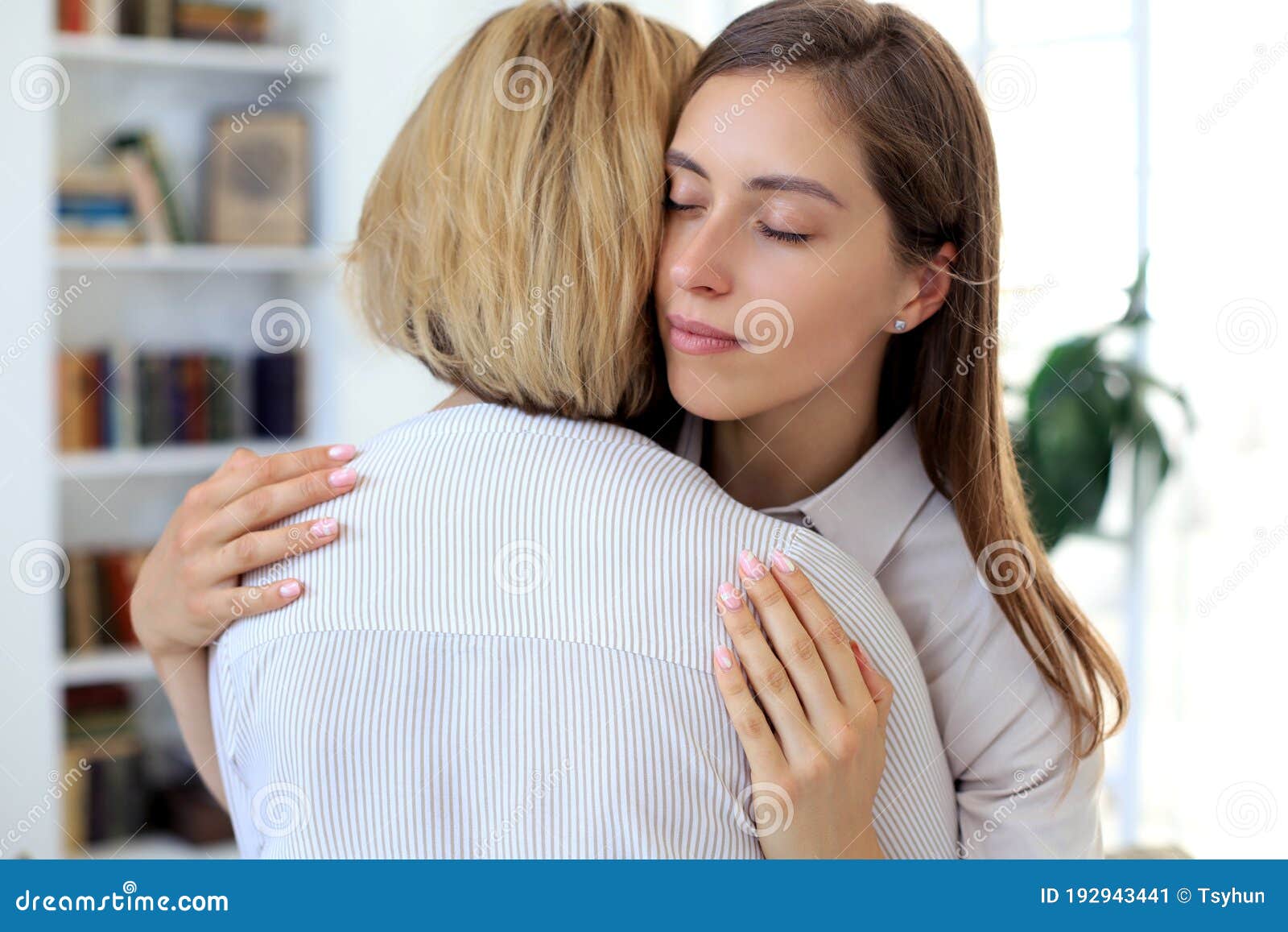 Concerned Middle Aged Mother And Adult Daughter Sit On Couch Having
