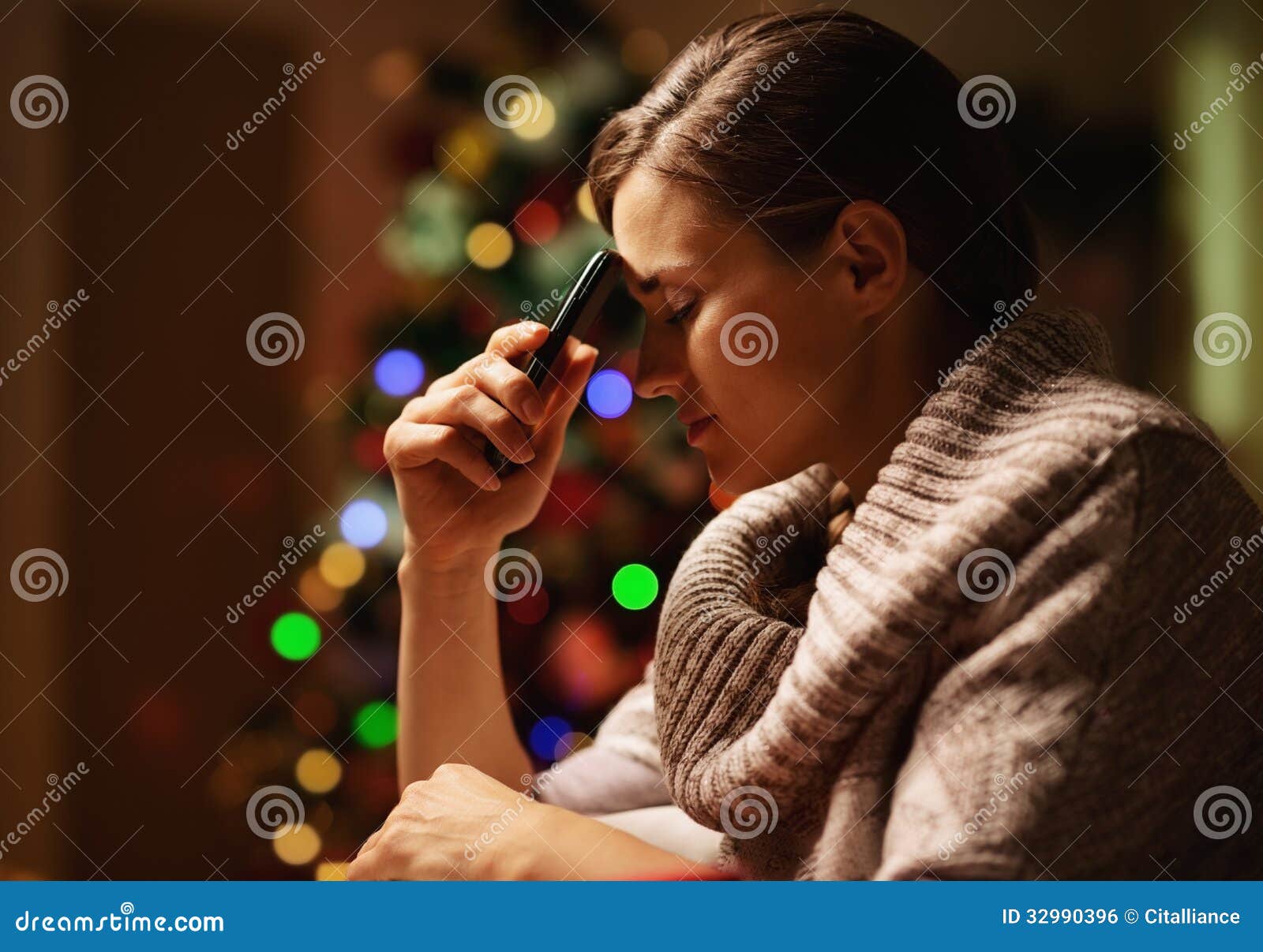 Concerned Woman with Mobile Phone in Front of Christmas Tree Stock ...