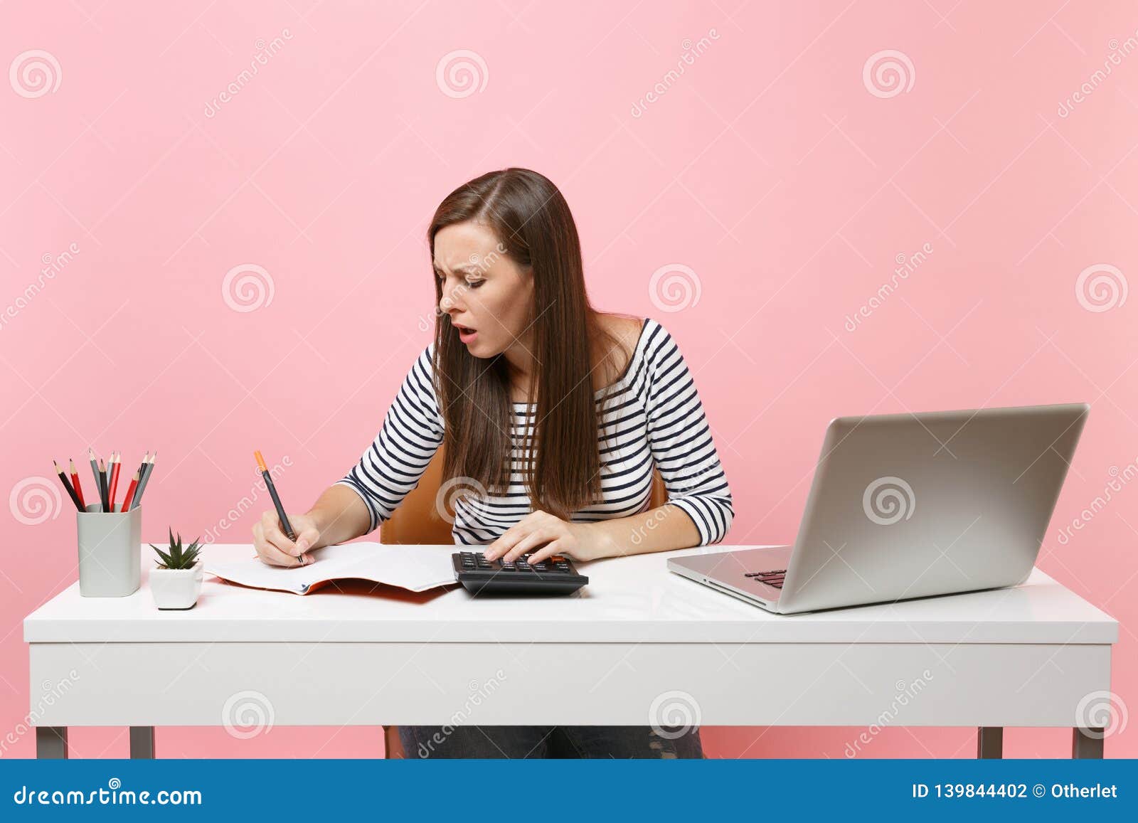 Concerned Woman Using Calculator Writing Notes with Calculations Sit ...