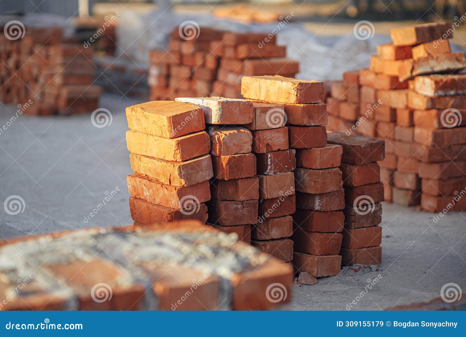 Concrete Foundation with Bricks for Laying. Stack of Red Bricks on ...