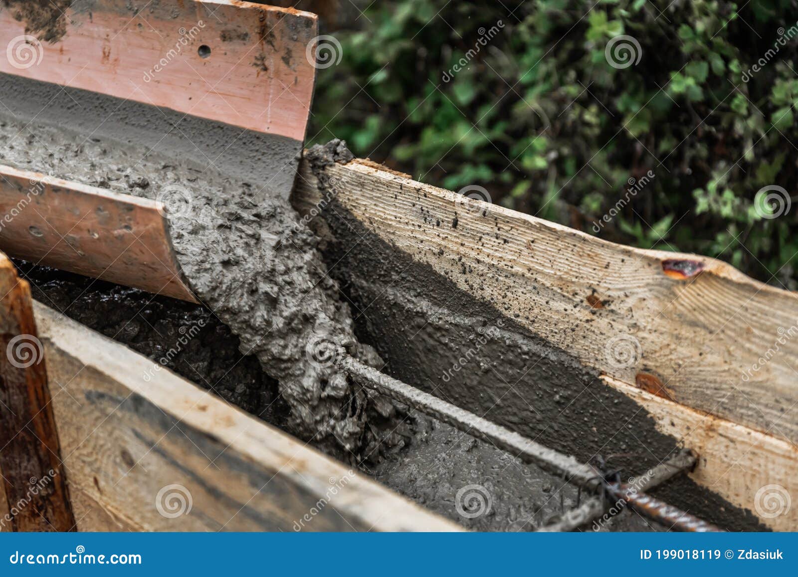 The Concrete Mixer Unloads the Concrete through a Chute into a Timber ...