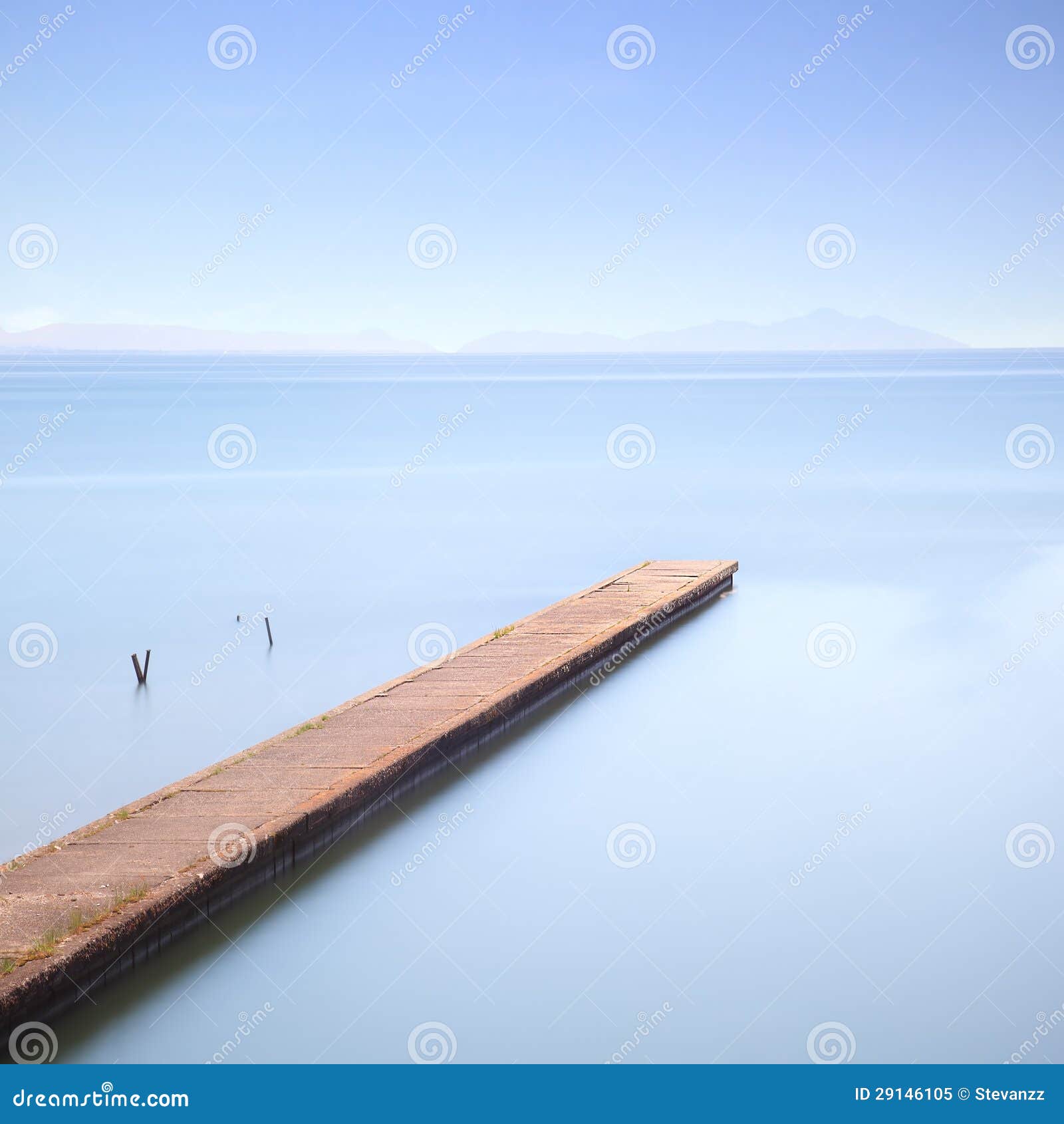 Concrete Pier or Jetty on a Blue Sea. Hills on Background Stock Image ...