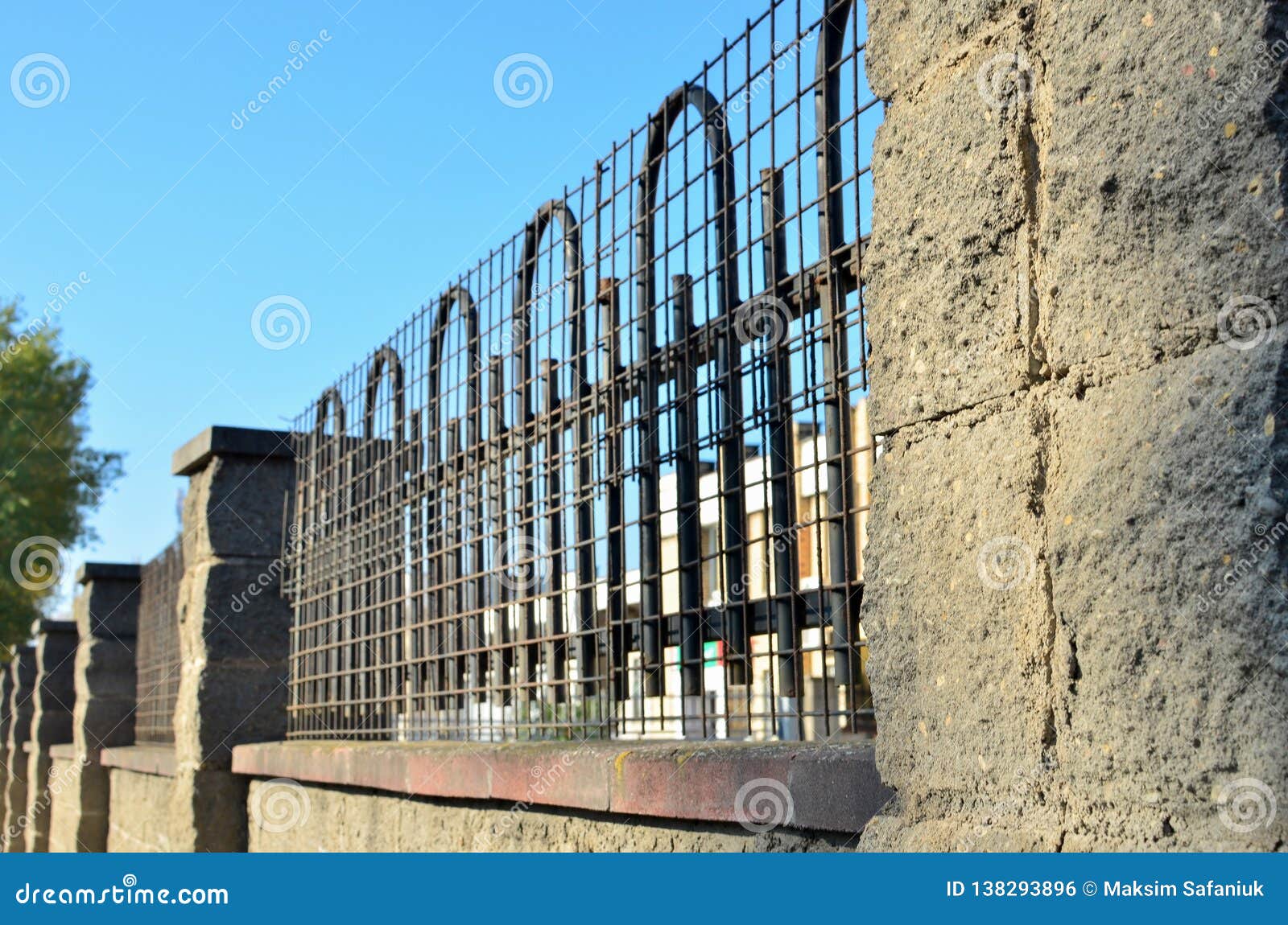 Concrete Wall with a Grooved Brick Block Surface with a Fence Stock ...