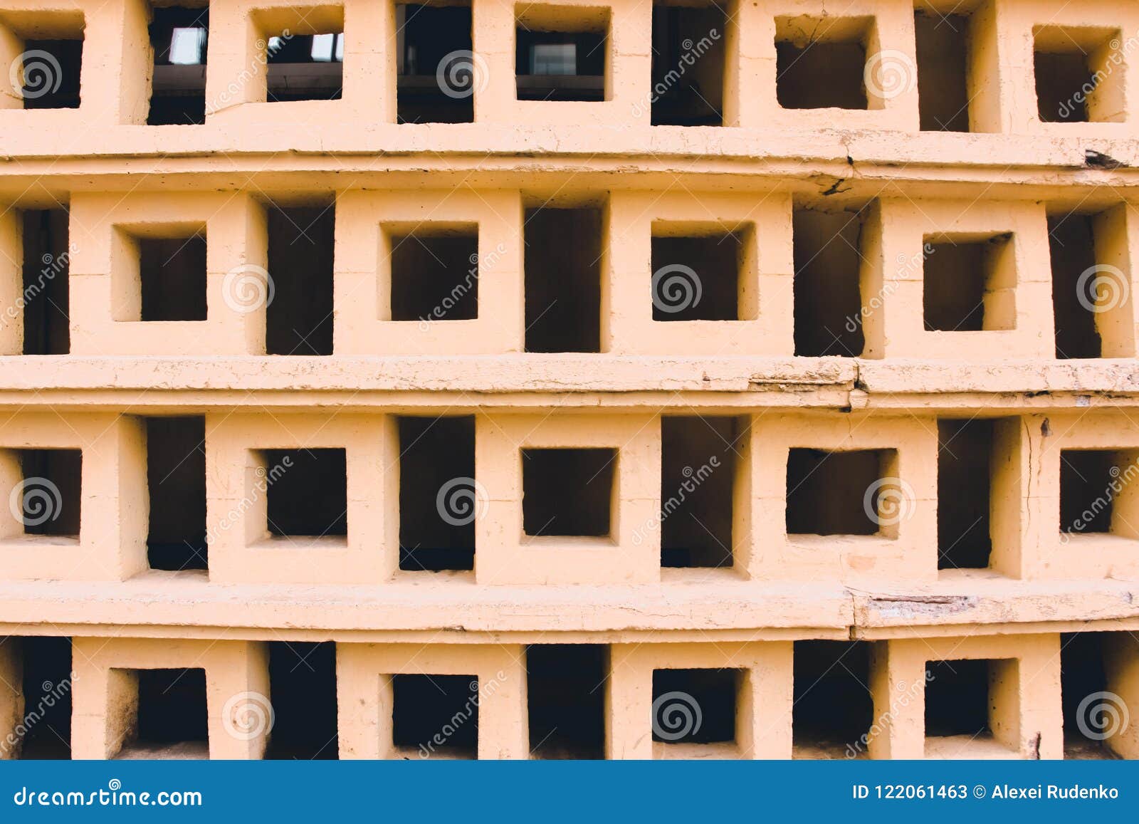 The Concrete Wall is Made in the Form of Squares. it is Painted Yellow ...