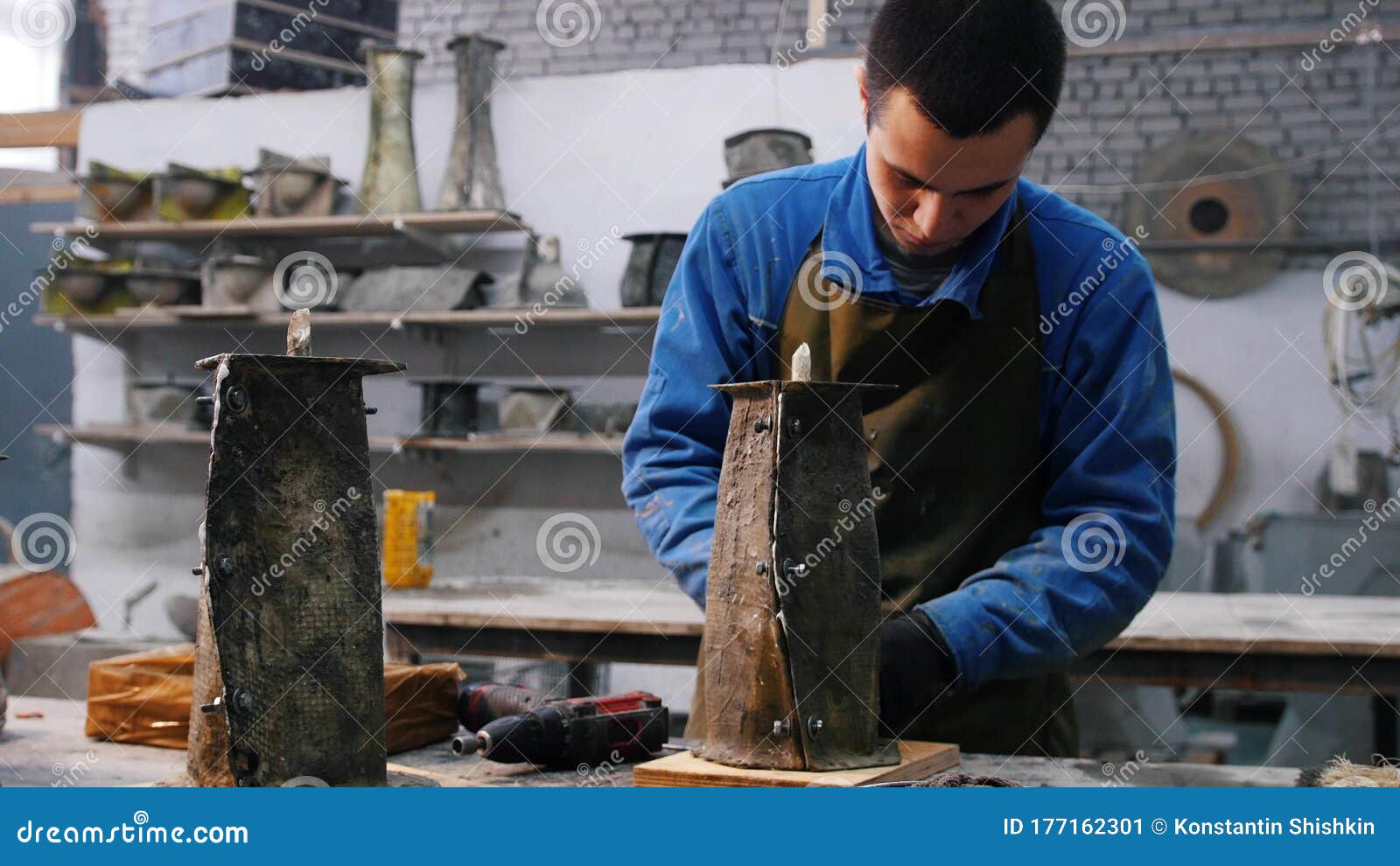 Concrete Workshop - a Man in a Blue Suit Working in a Concrete Workshop ...