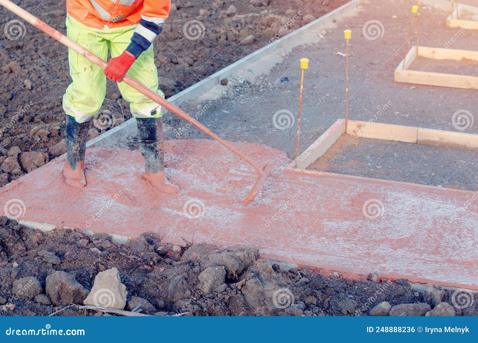Concreter Spreading Poured Concrete with Rake or Spazzle a Construction ...