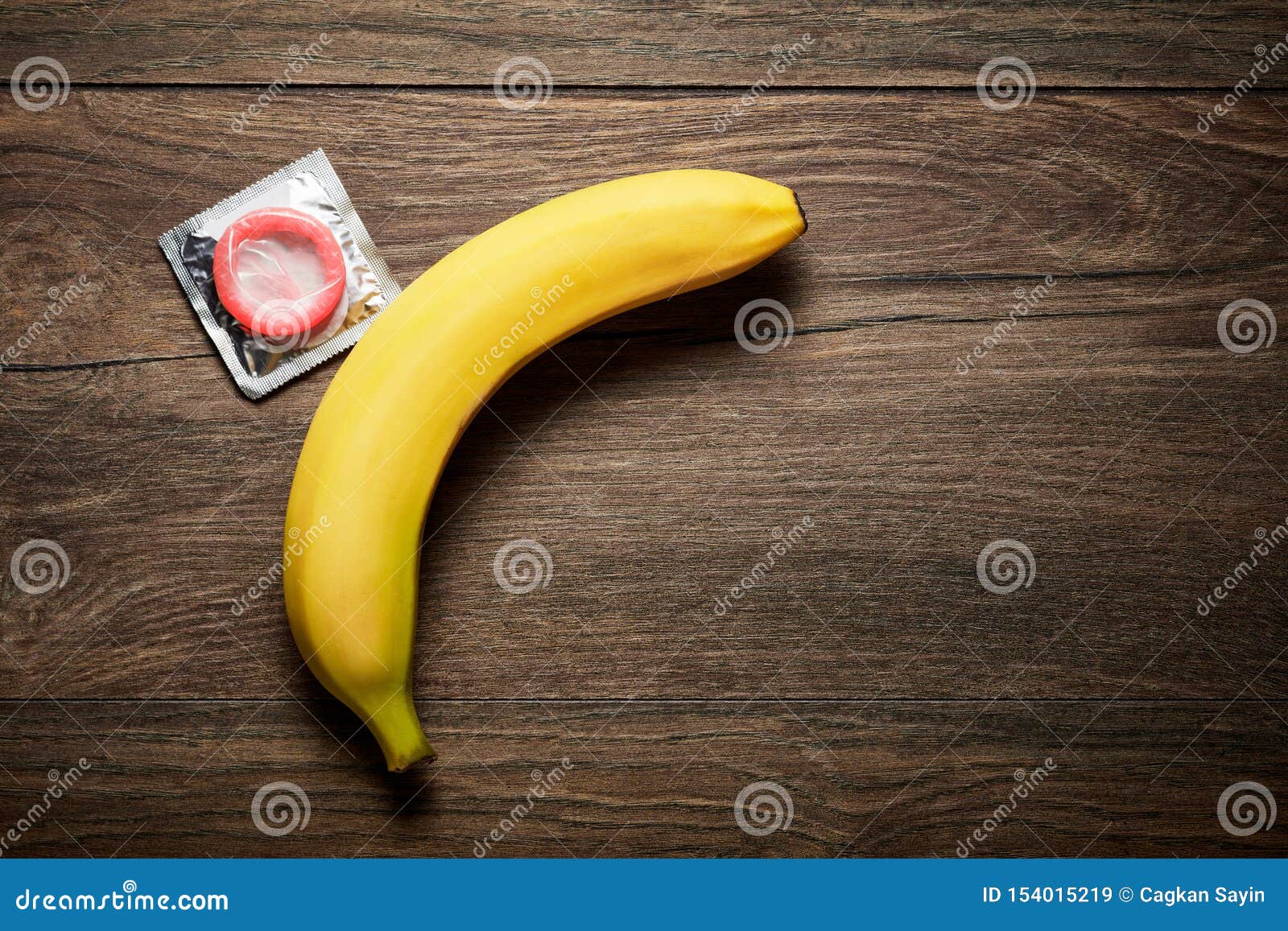 Condom And Banana On A Wooden School Desk Concept Of Sex Education