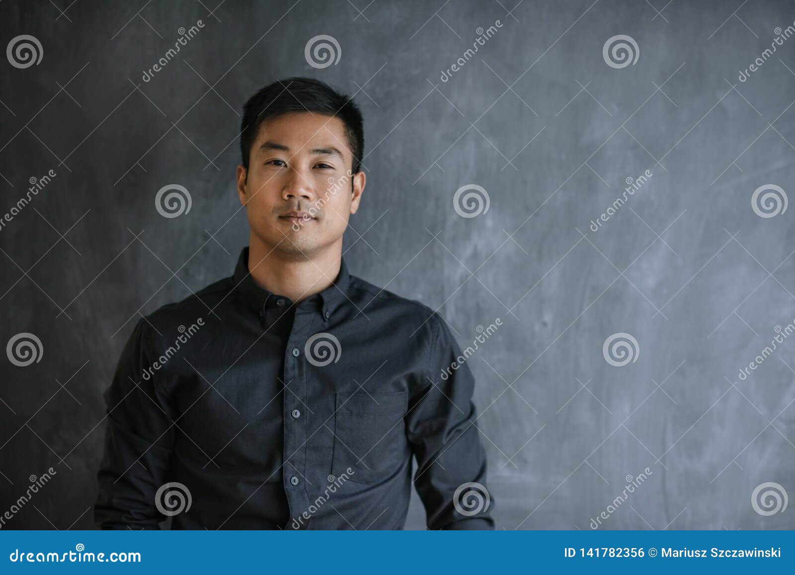 Confident Asian Businessman Standing in Front of a Blank Chalkboard ... Confident Asian Businessman Standing in Front of a Blank Chalkboard ...