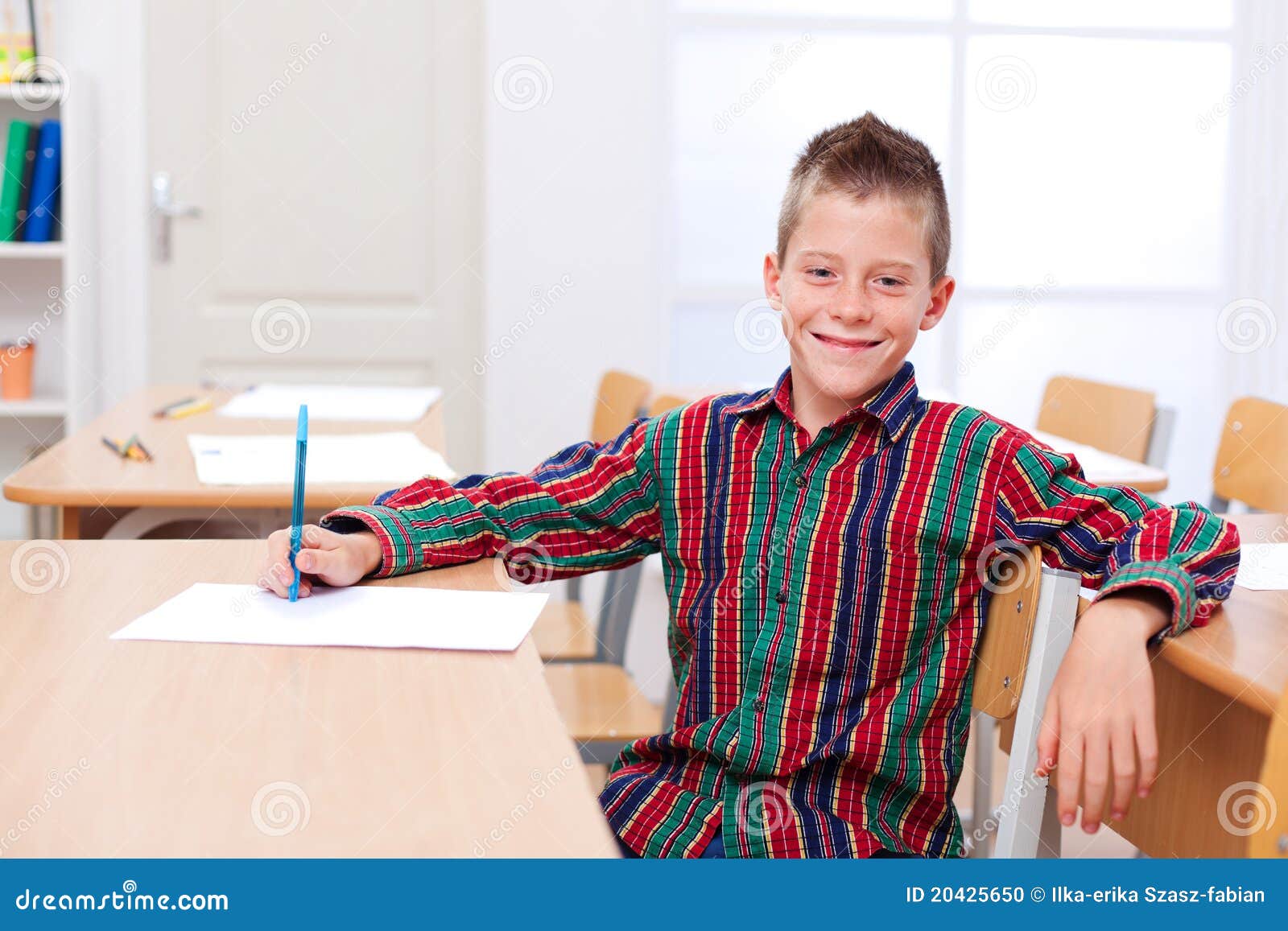 Confident Boy Sitting Alone In Classroom Stock Photo | CartoonDealer ...