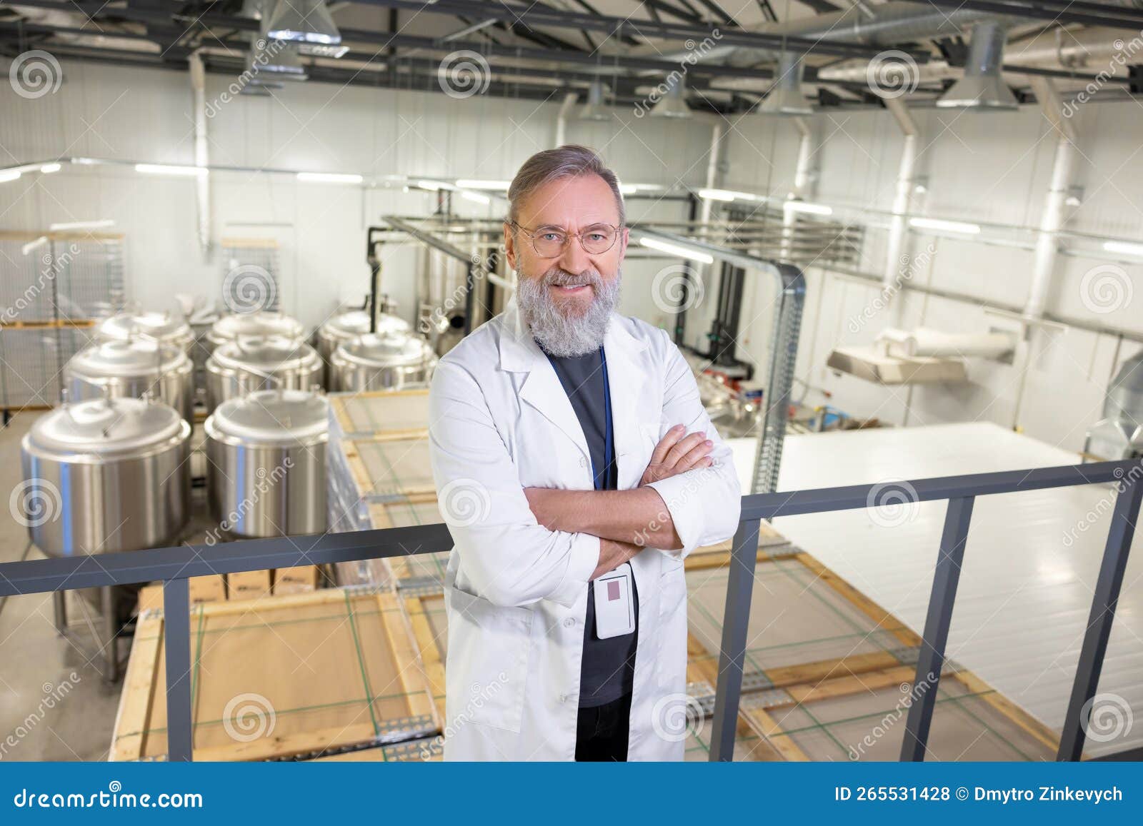 Confident Brewer Posing for the Camera Against Beer Fermentation Tanks ...