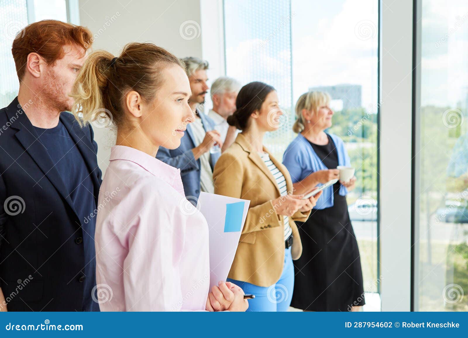 Confident Business Team Looking Out of Window while Standing Together ...