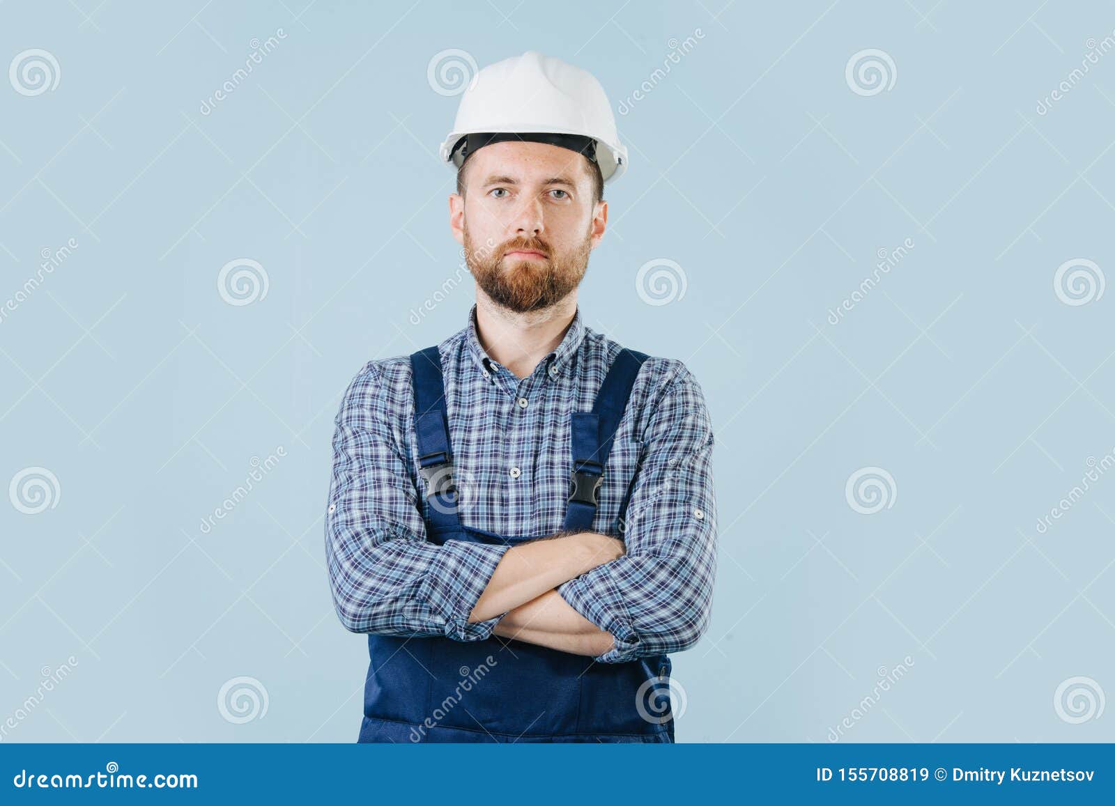 Confident Construction Worker in a White Helmet and Blue Overalls Stock ...