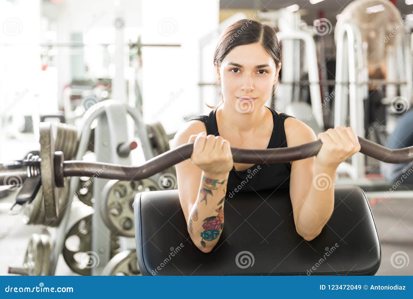 Confident Female Athlete Lifting Barbell Curl on Exercise Machine Stock ... Confident Female Athlete Lifting Barbell Curl on Exercise Machine Stock ...