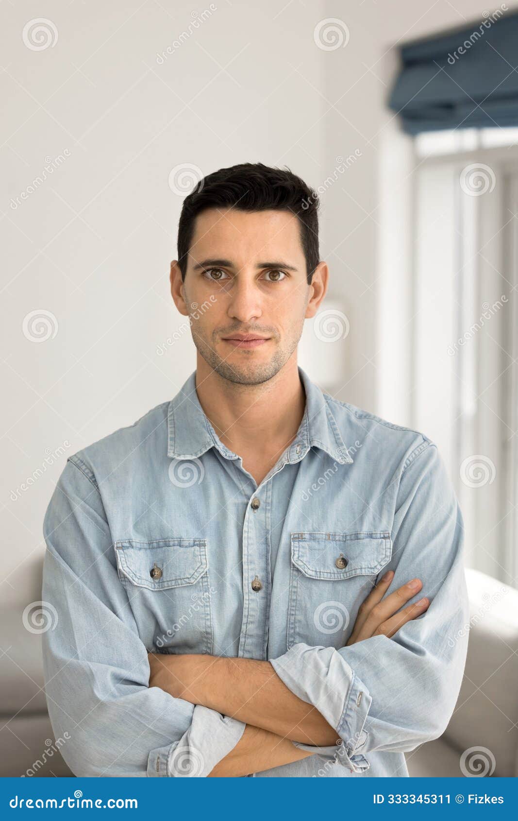Handsome Hispanic Man Standing Shirtless Pointing To The Back Behind