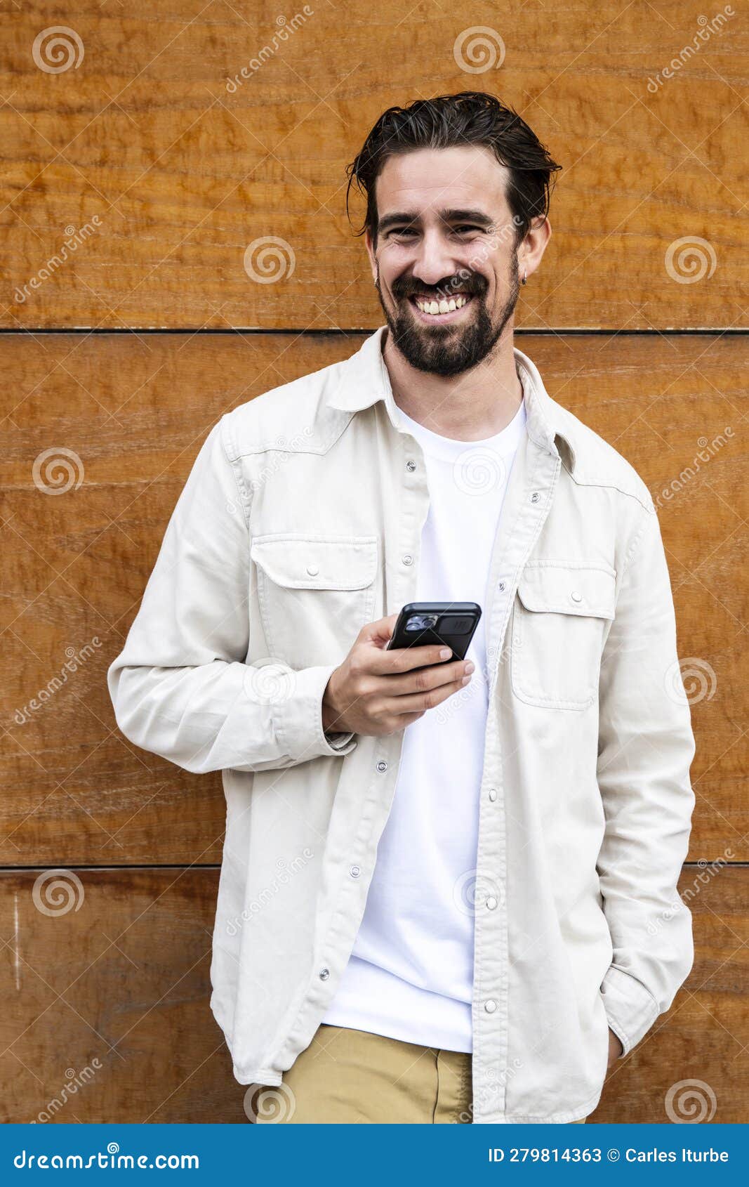 Confident Handsome Young Guy Texting with His Phone and Looking at ...