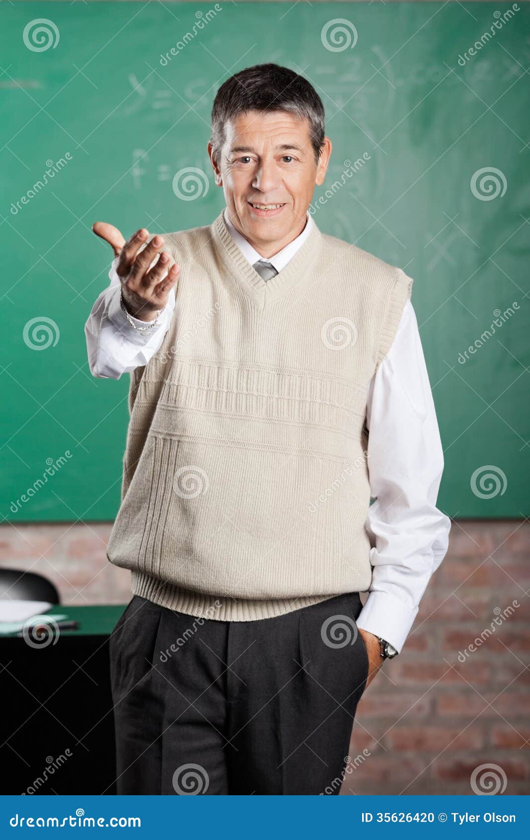 Confident Professor Gesturing in Classroom Stock Photo - Image of arms ...