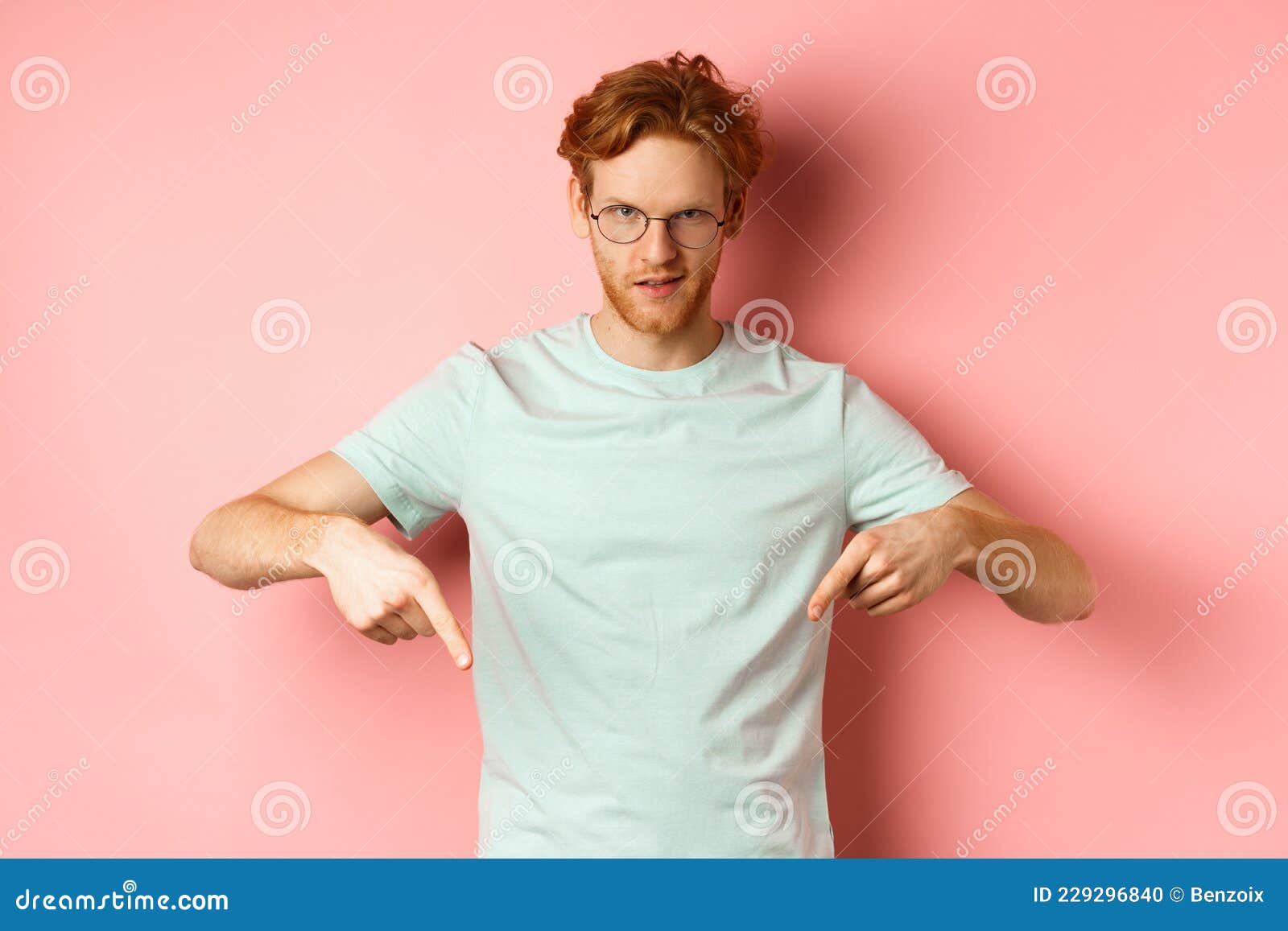 Confident Redhead Man In Glasses Pointing Fingers Down Staring Daring