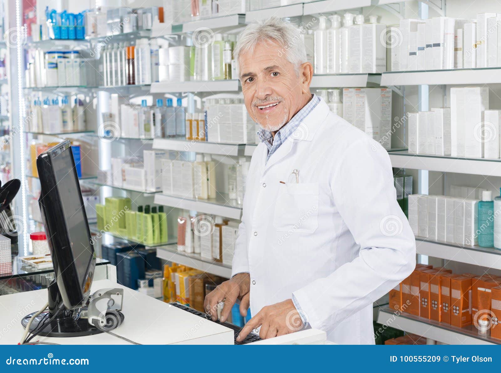 Senior Chemist Using Computer at Counter in Pharmacy Stock Image ...