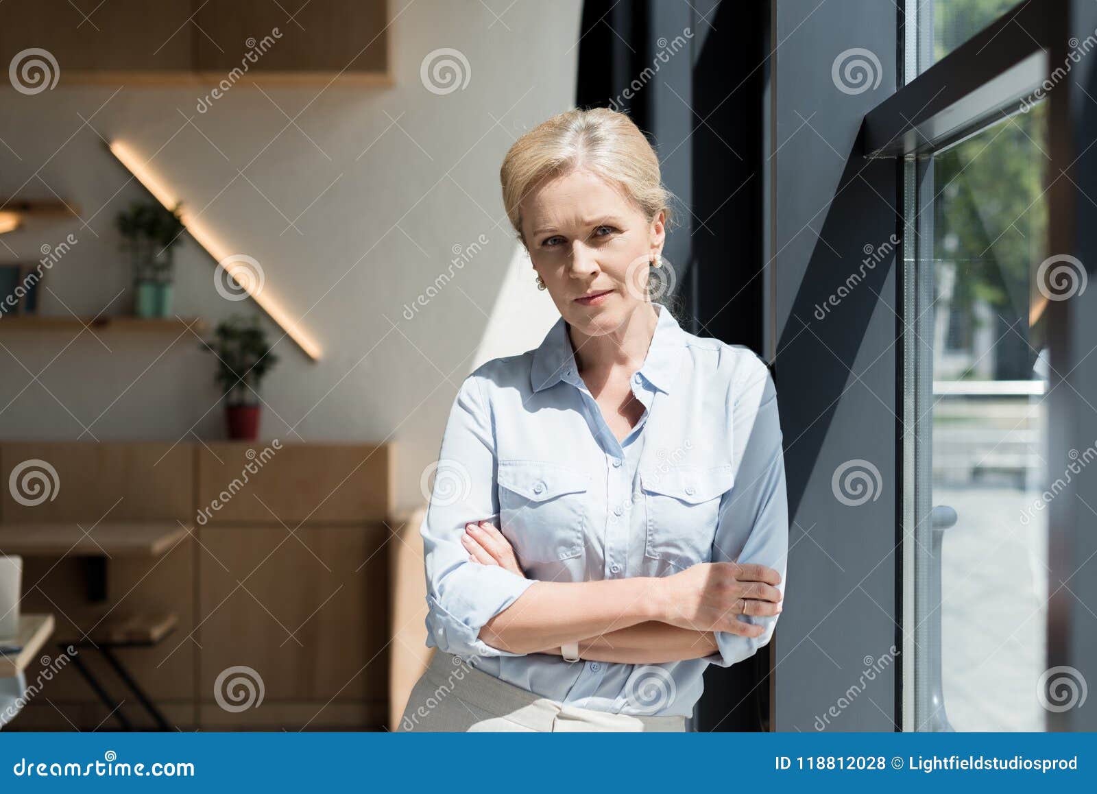 Confident Serious Mature Woman Standing with Crossed Arms and Looking ... Confident Serious Mature Woman Standing with Crossed Arms and Looking ...
