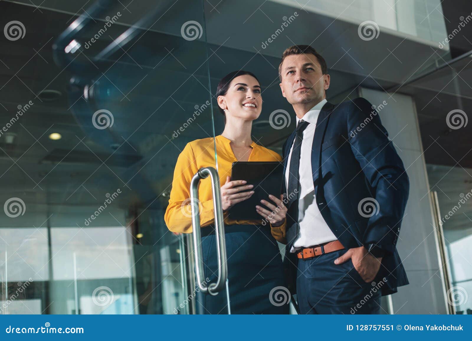 Confident Smiling Co-workers Standing Behind Transparent Wall Stock ...