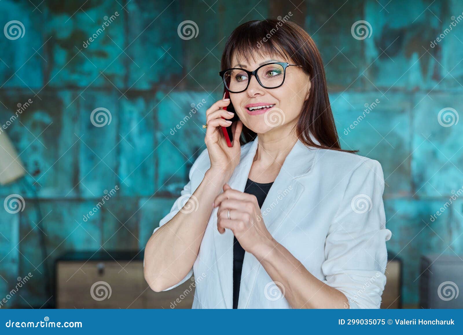 Mature Business Woman Talking On Mobile Phone In Office Stock Image