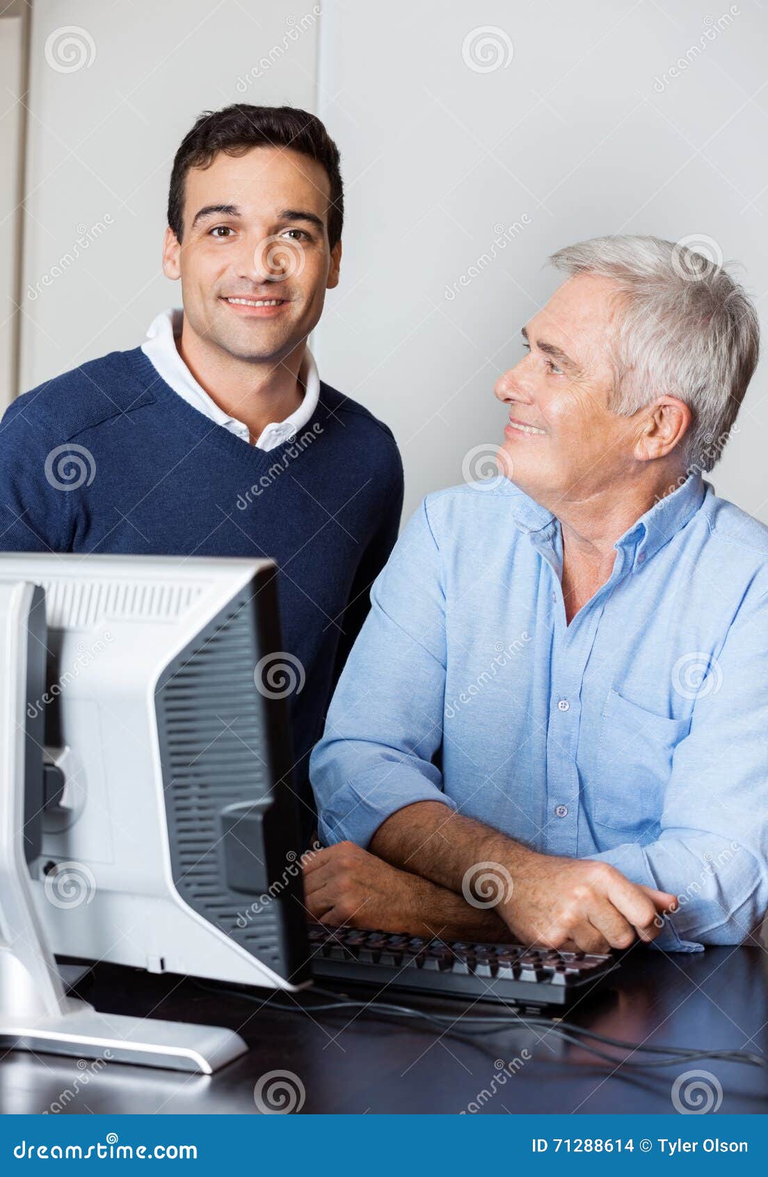 Confident Tutor with Senior Student in Computer Lab Stock Photo - Image ...