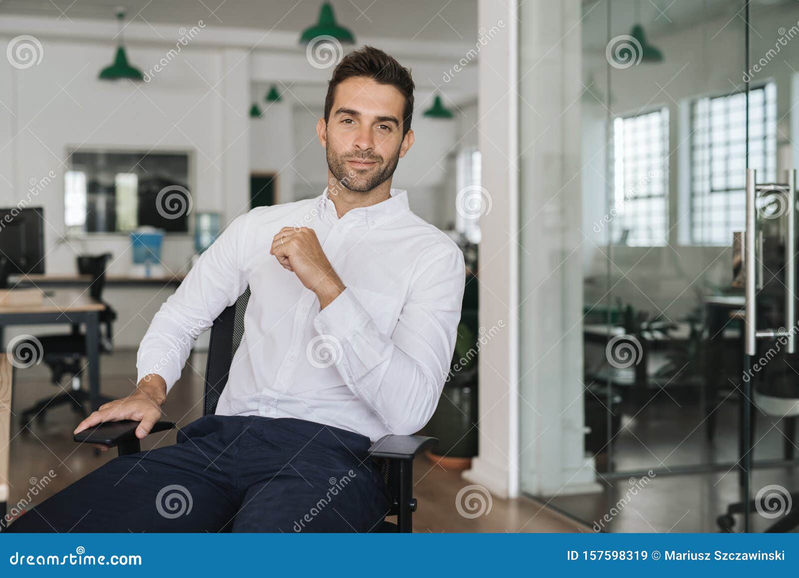 Confident Young Businessman Sitting in a Chair in an Office Stock Image ... Confident Young Businessman Sitting in a Chair in an Office Stock Image ...
